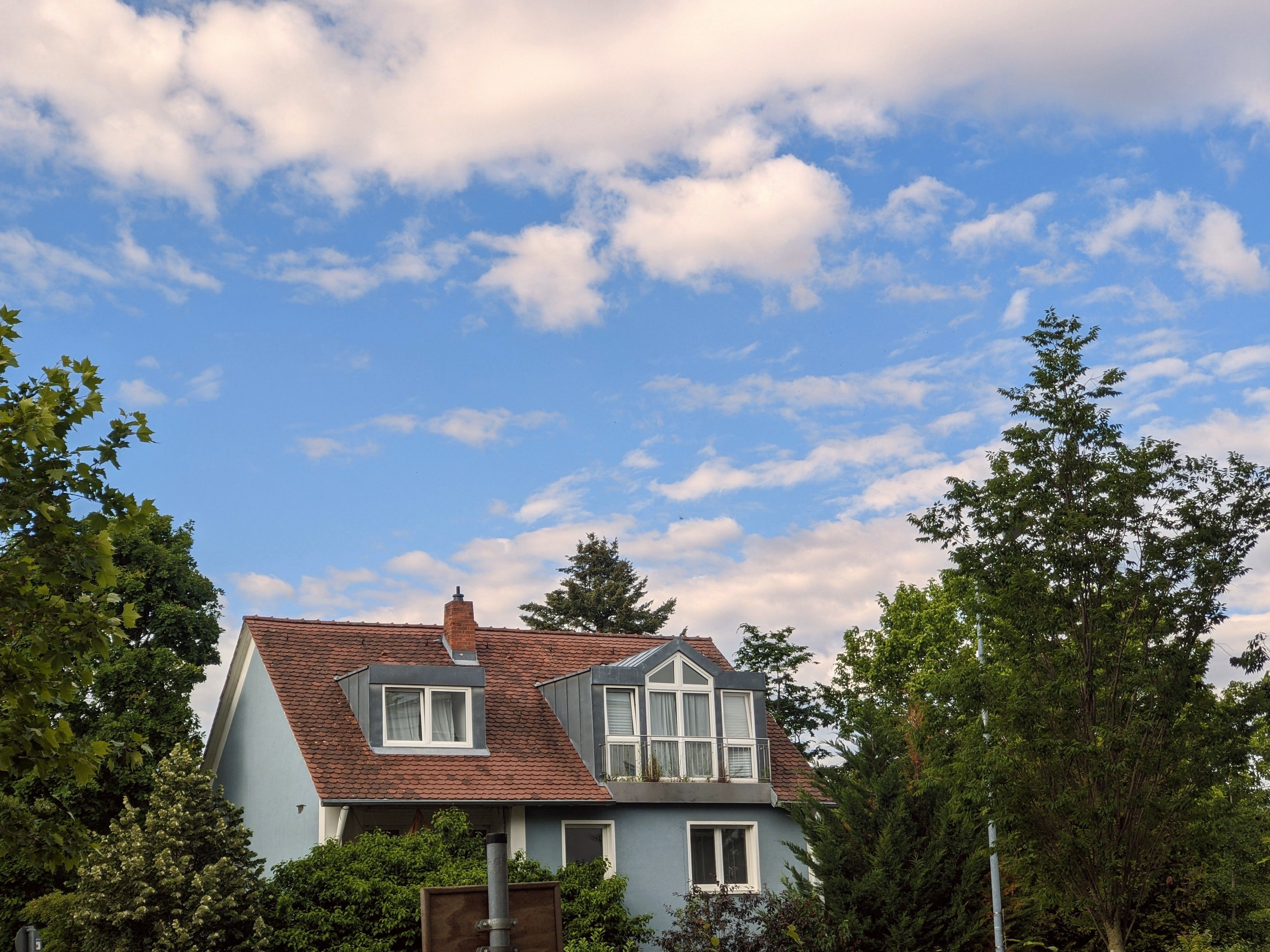 Charming Blue House with Red Roof Under Blue Sky · Free Stock Photo