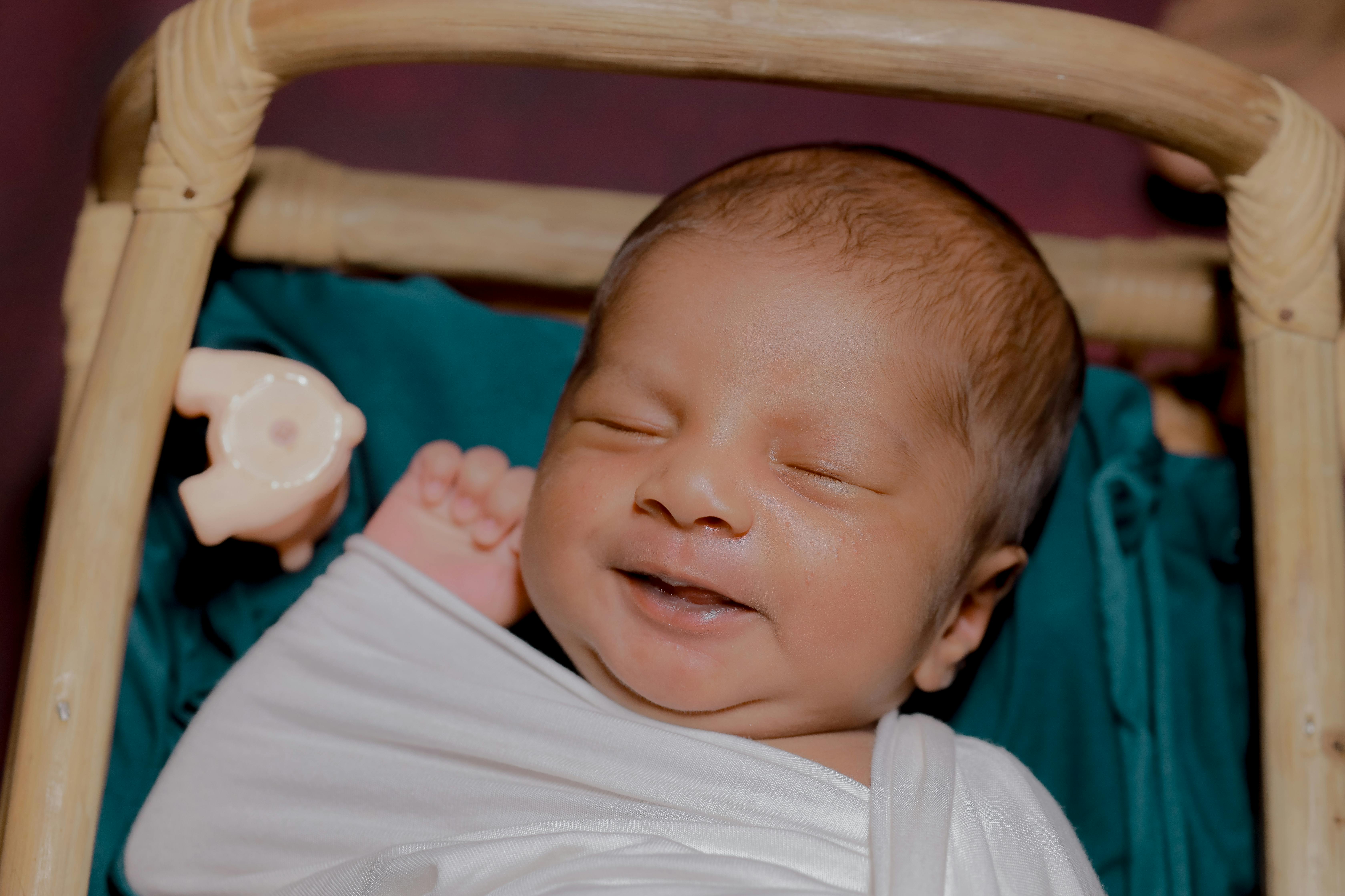 Smiling South Asian Baby in Cradle Indoors · Free Stock Photo