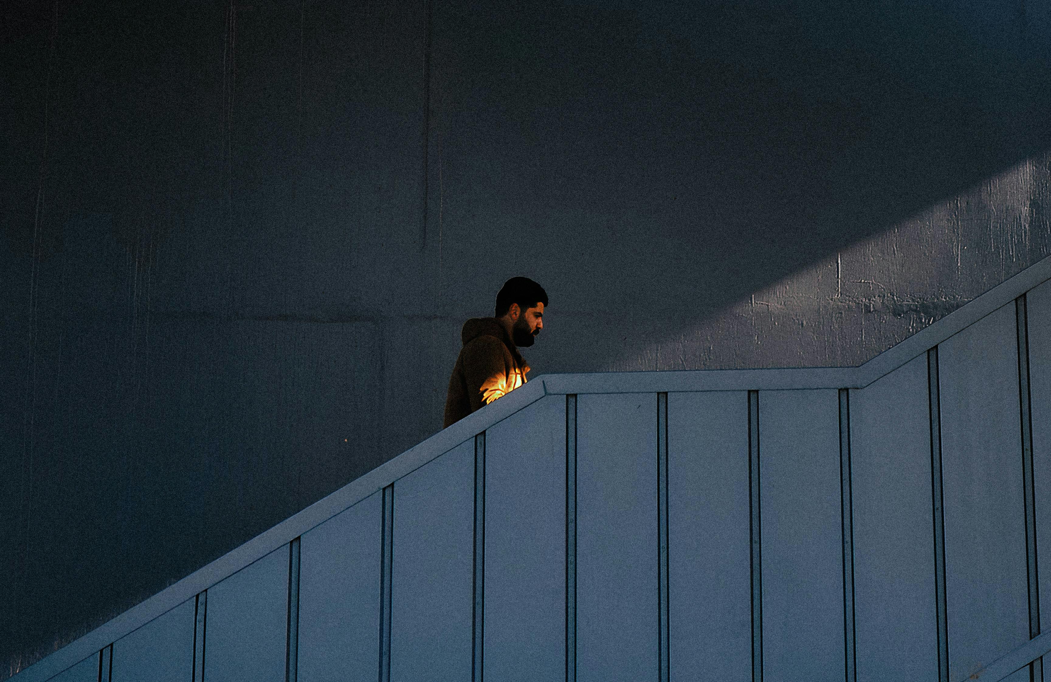 Man Walking Downstairs in Shadowy Space · Free Stock Photo