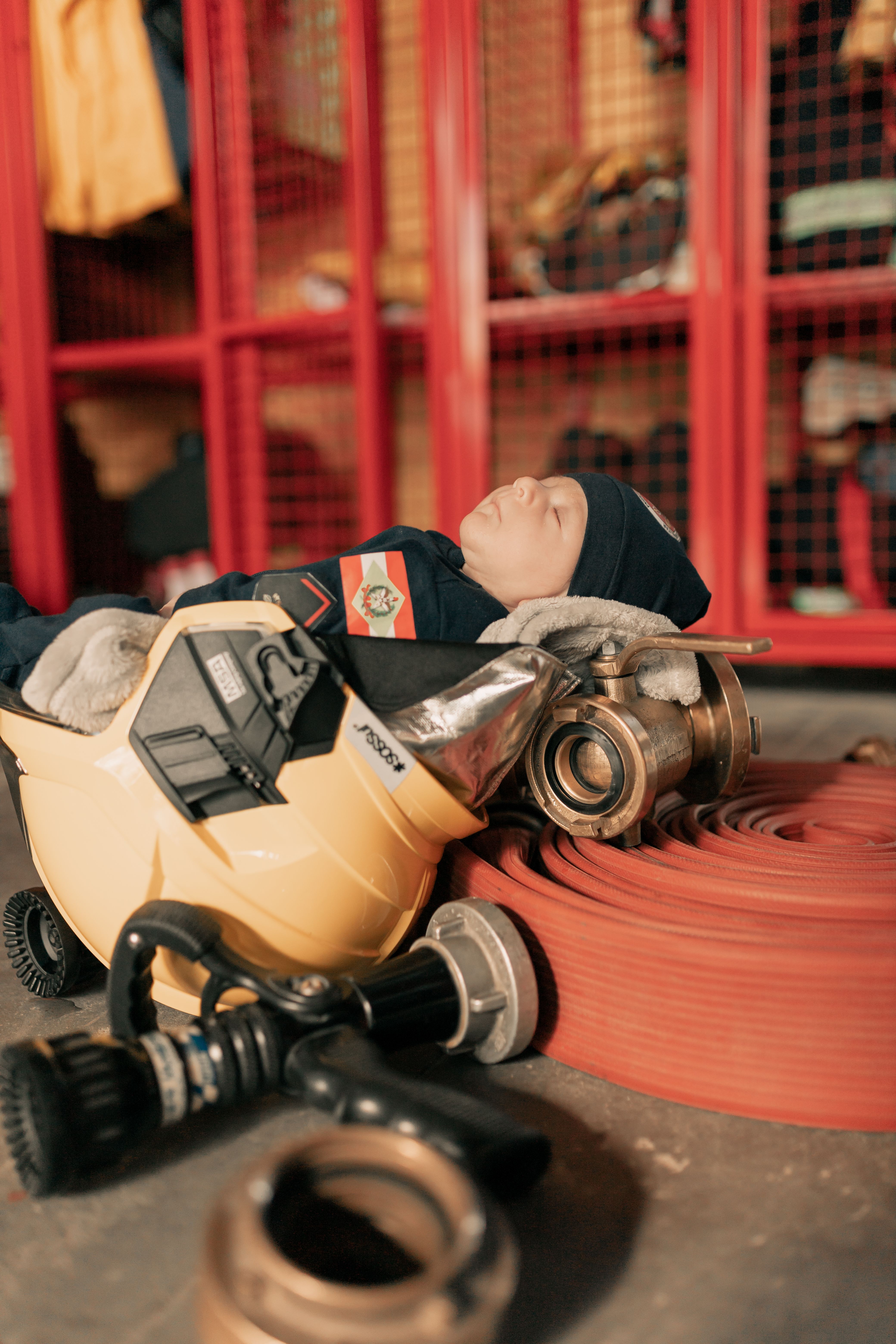 Baby wearing firefighter costume in locker room · Free Stock Photo