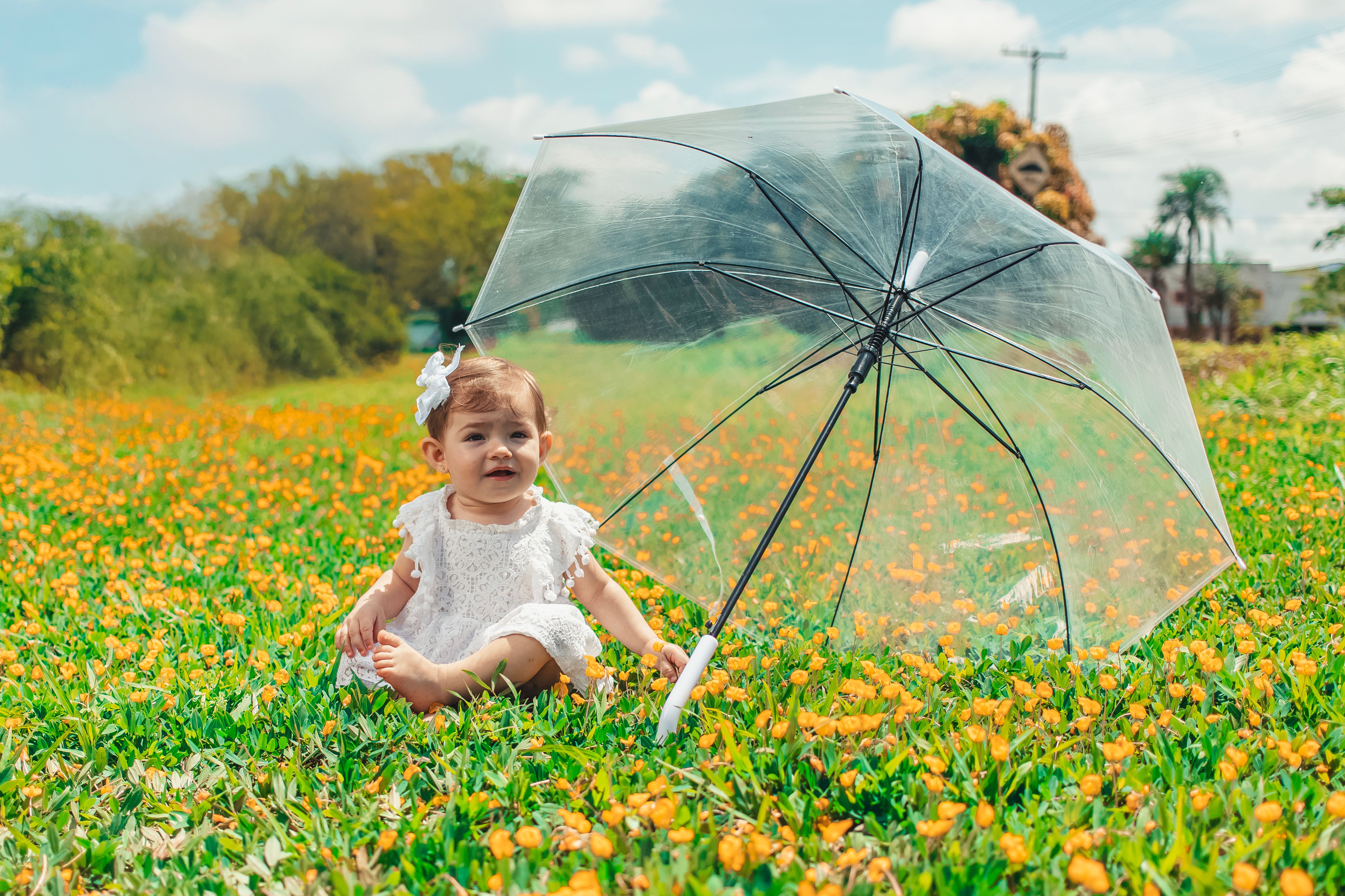 Smiling Baby in Floral Field with Umbrella · Free Stock Photo