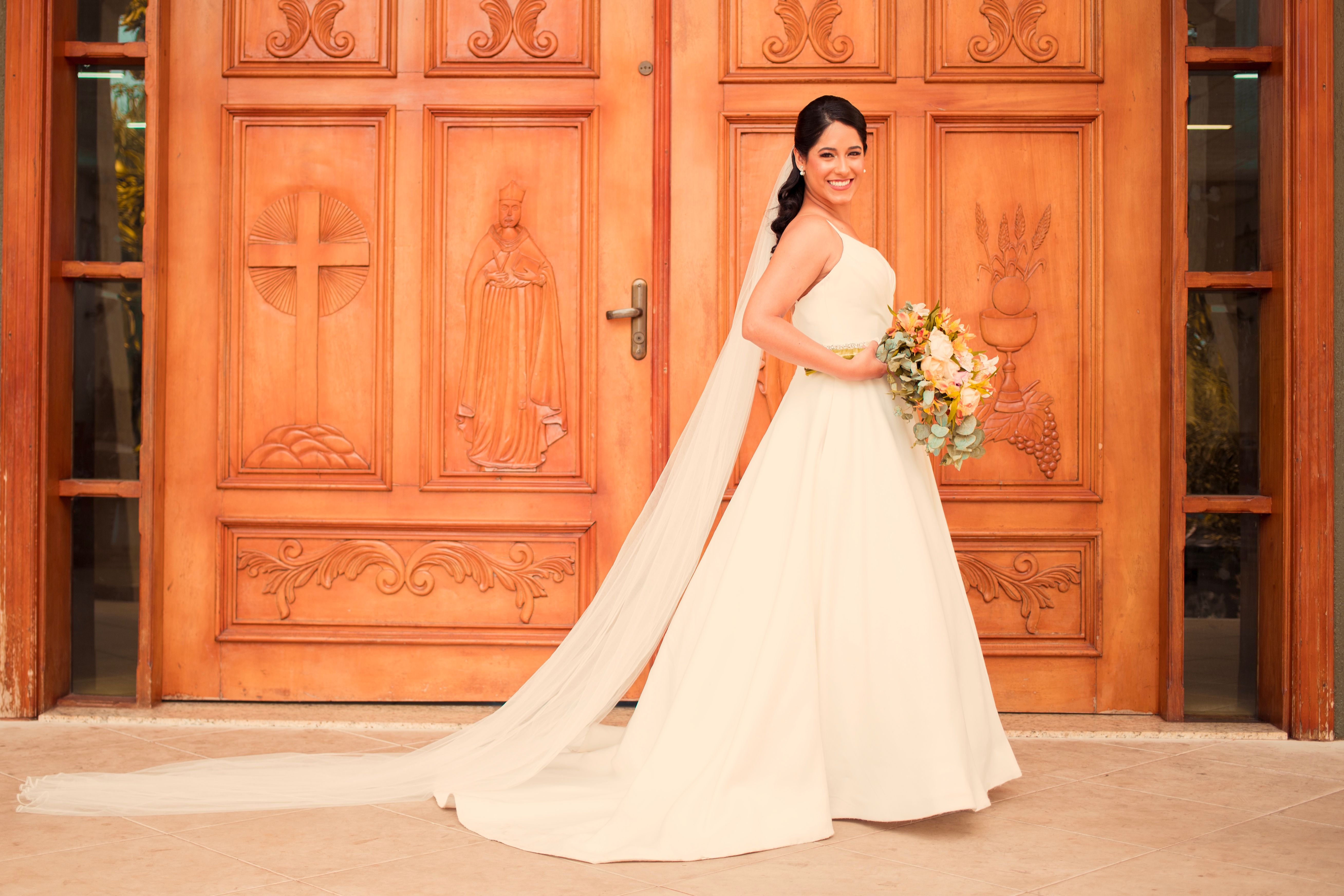 Elegant Bride in White Gown at Ornate Wooden Door · Free Stock Photo