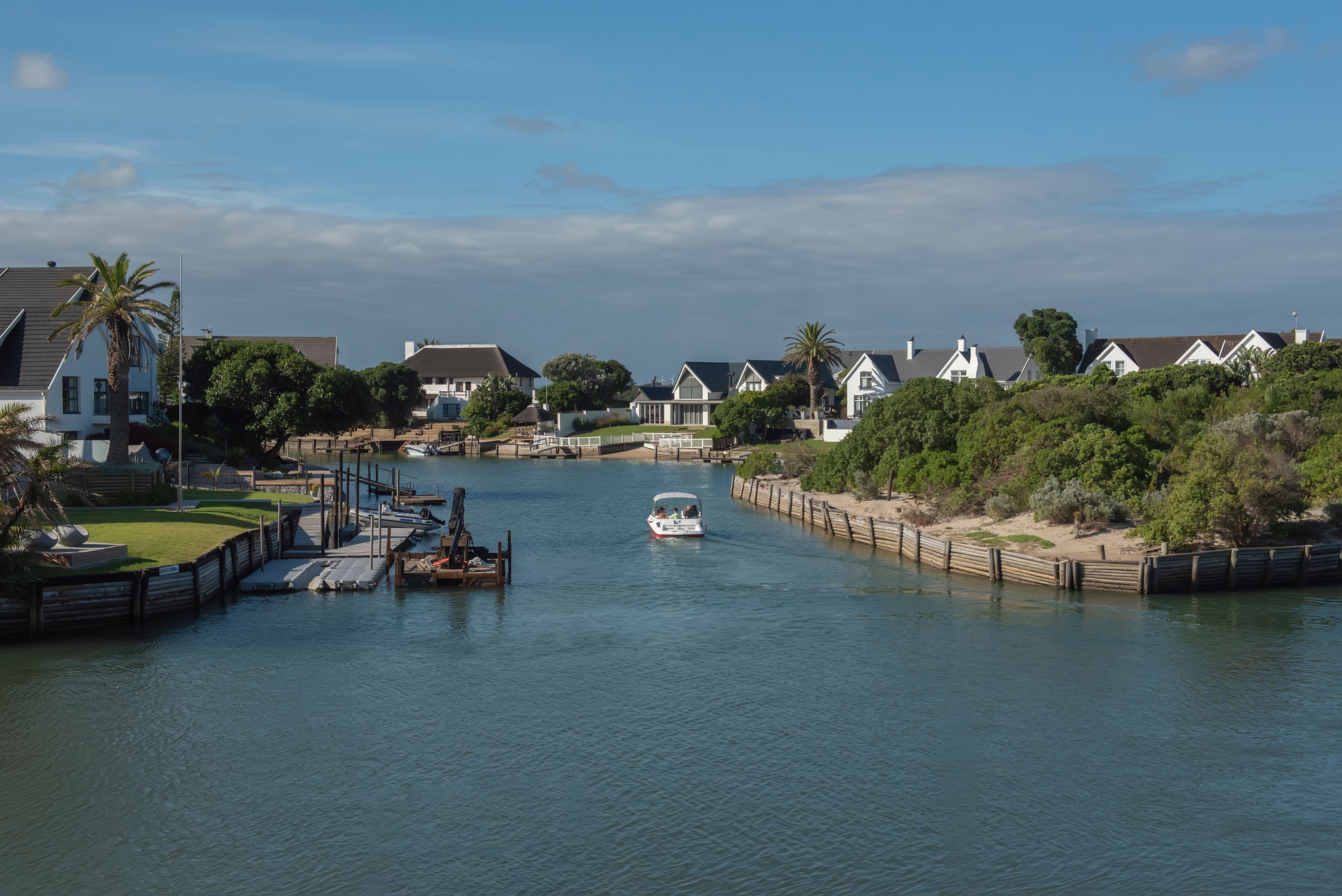 Scenic Riverfront with Residential Homes and Boat · Free Stock Photo
