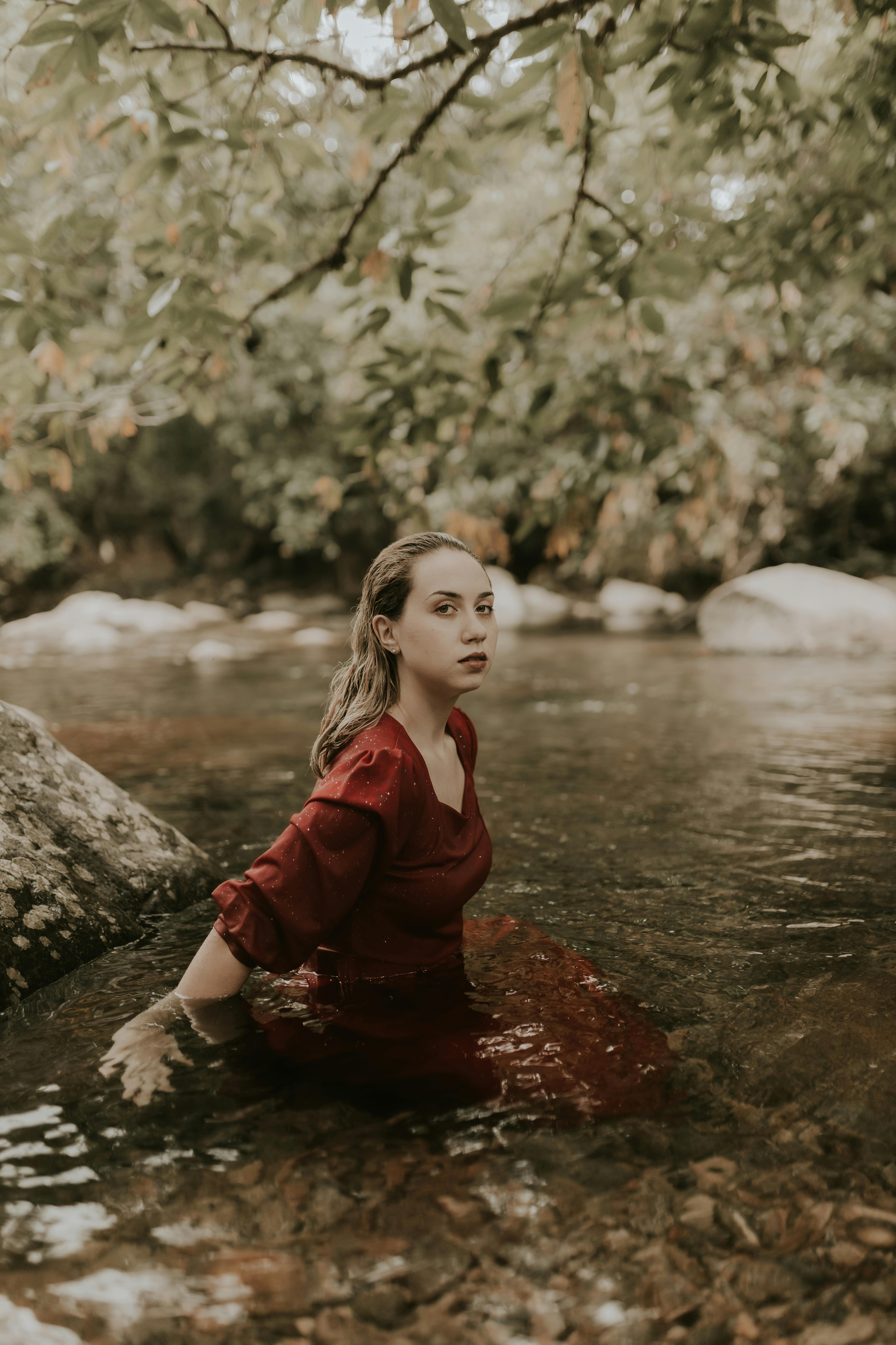 Woman in Red String Spaghetti Strap Dress on Body of Water Near Forest ...