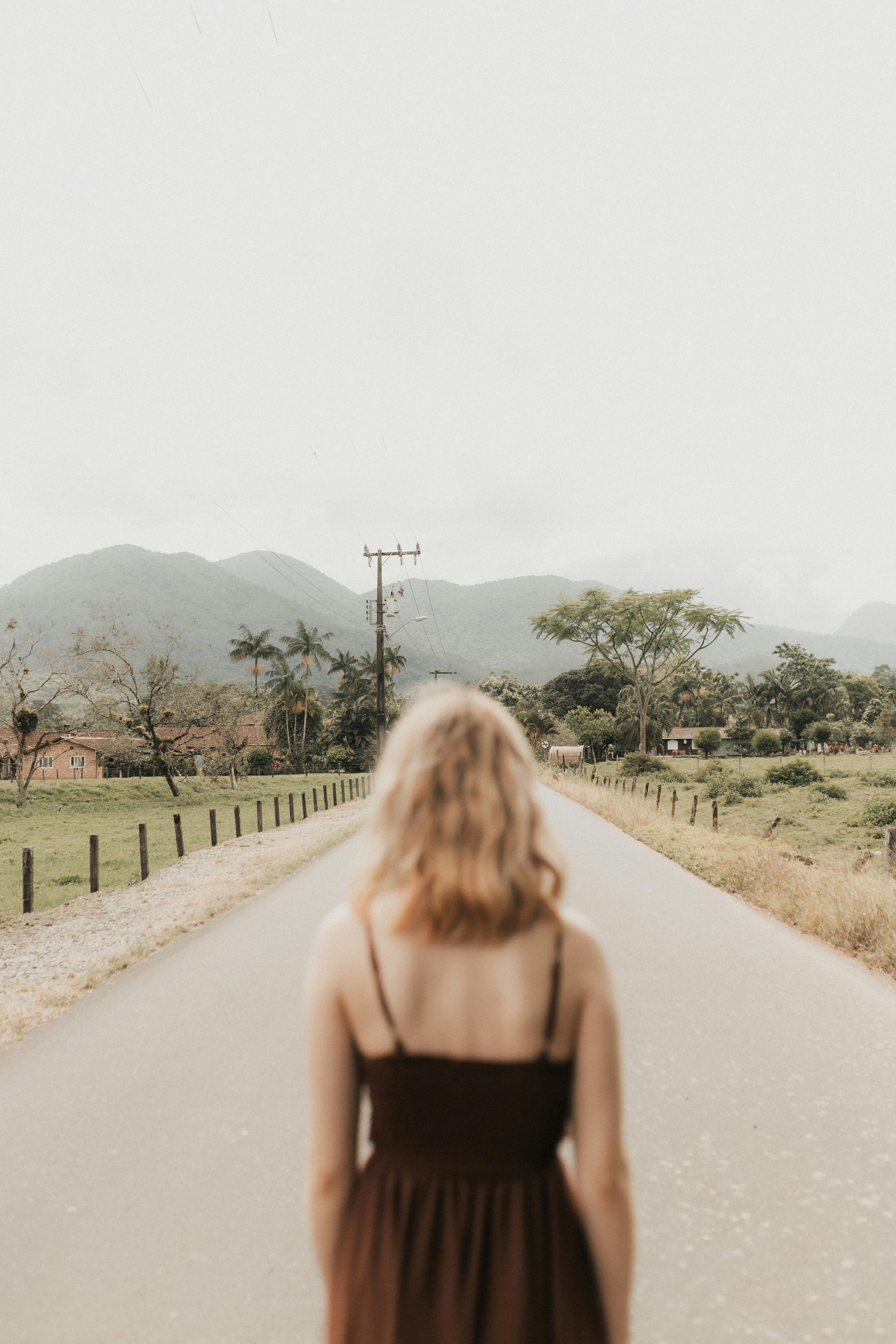 Woman Walking on Rural Road with Mountain View · Free Stock Photo