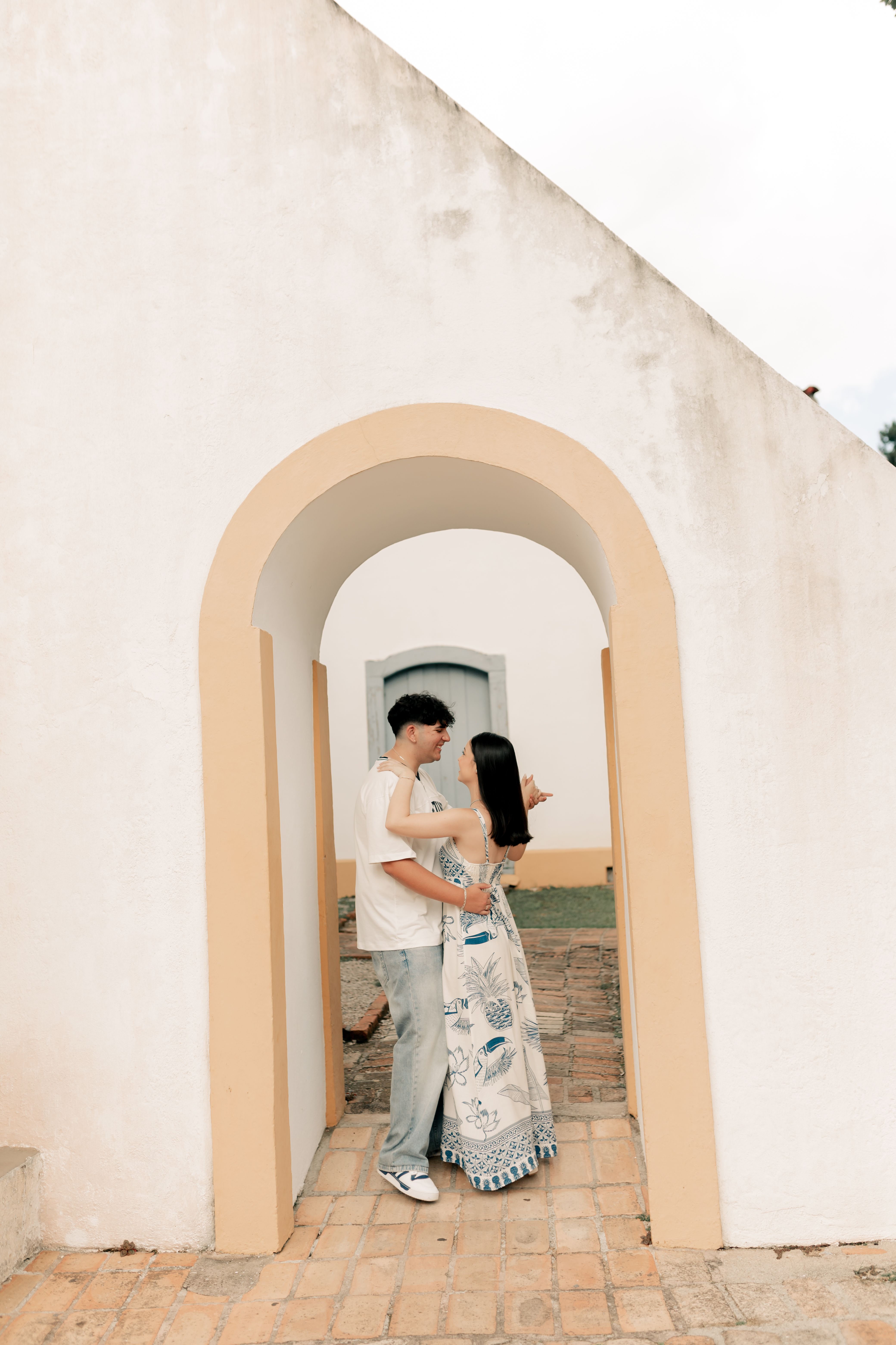 Romantic Couple Embracing Under Archway · Free Stock Photo