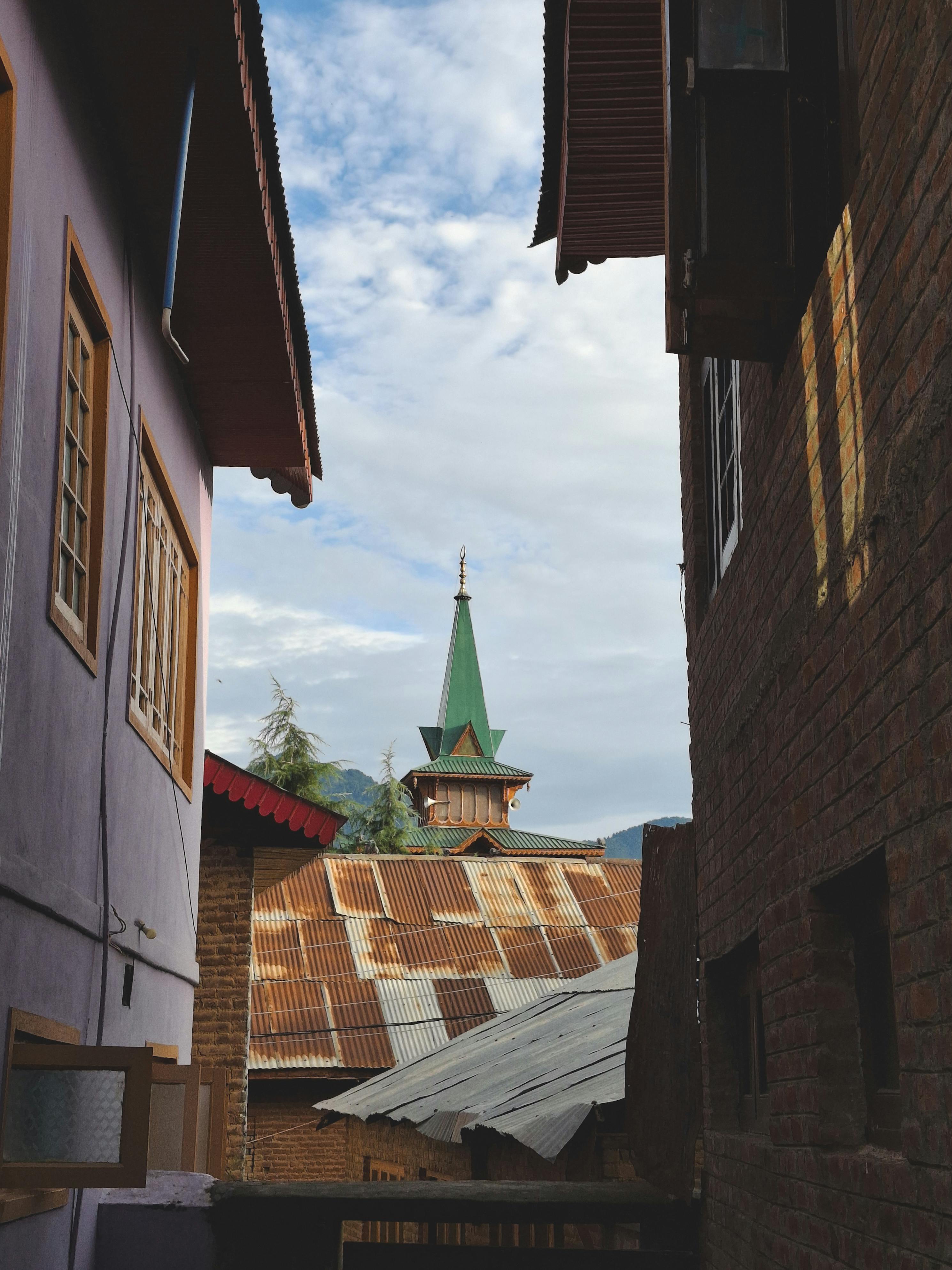 Rustic Alleyway with Mountain View and Tower · Free Stock Photo
