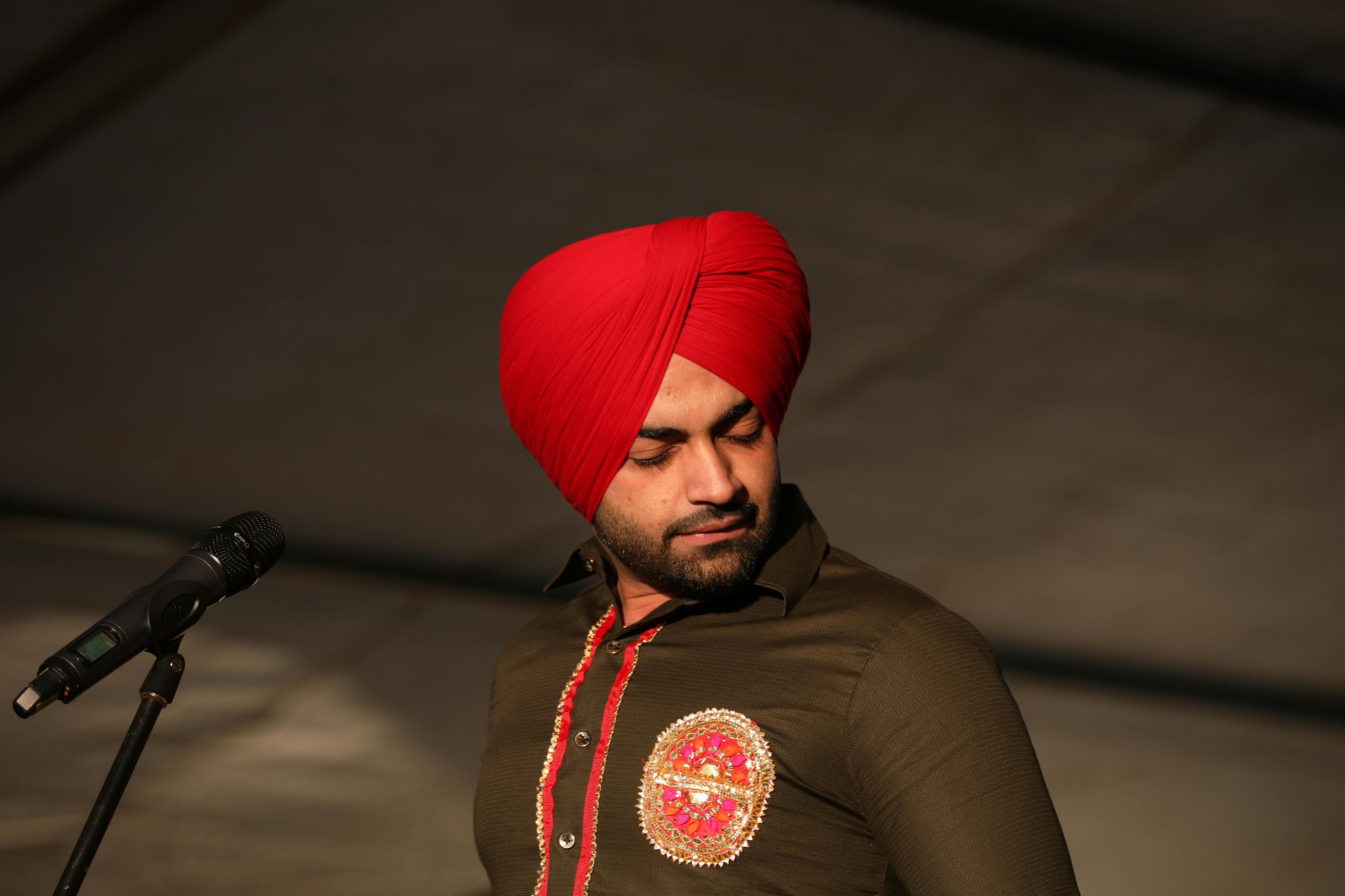 Sikh Man in Red Turban Performing on Stage · Free Stock Photo