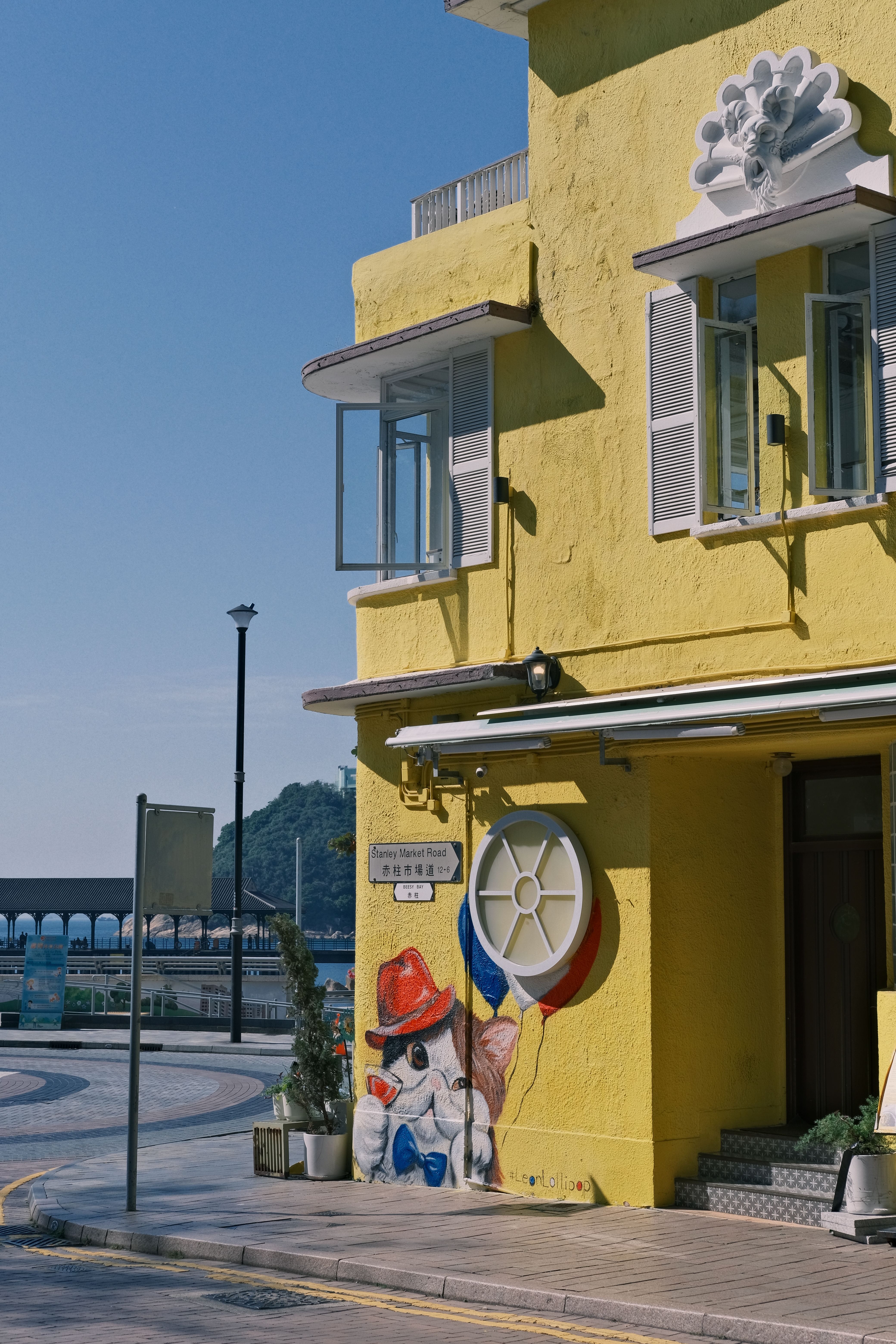 Vibrant Yellow Building by a Coastal Walkway · Free Stock Photo