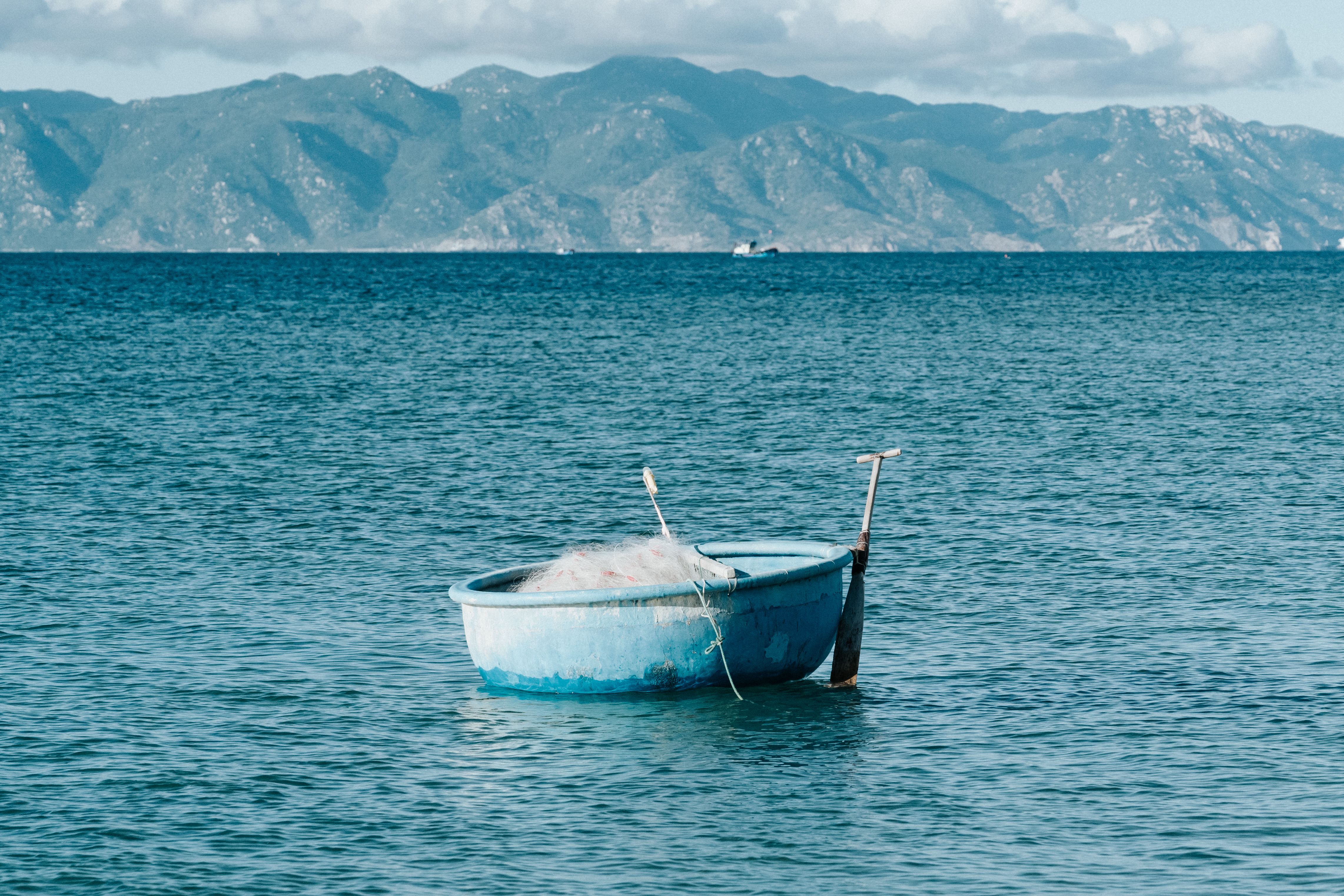 Tranquil Blue Boat on Ocean with Mountain View · Free Stock Photo