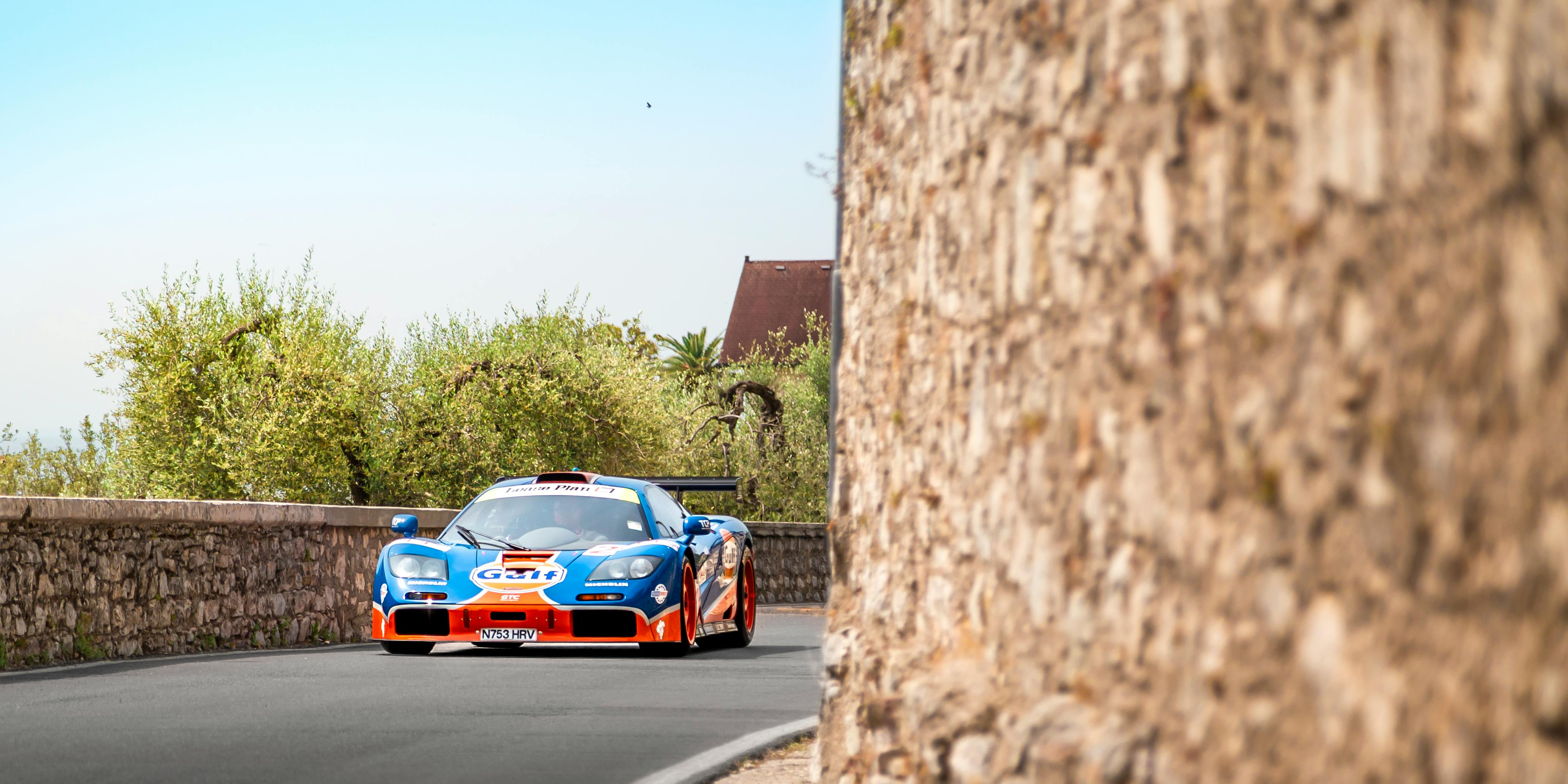 Racing Supercar on Scenic Stone Wall Road · Free Stock Photo
