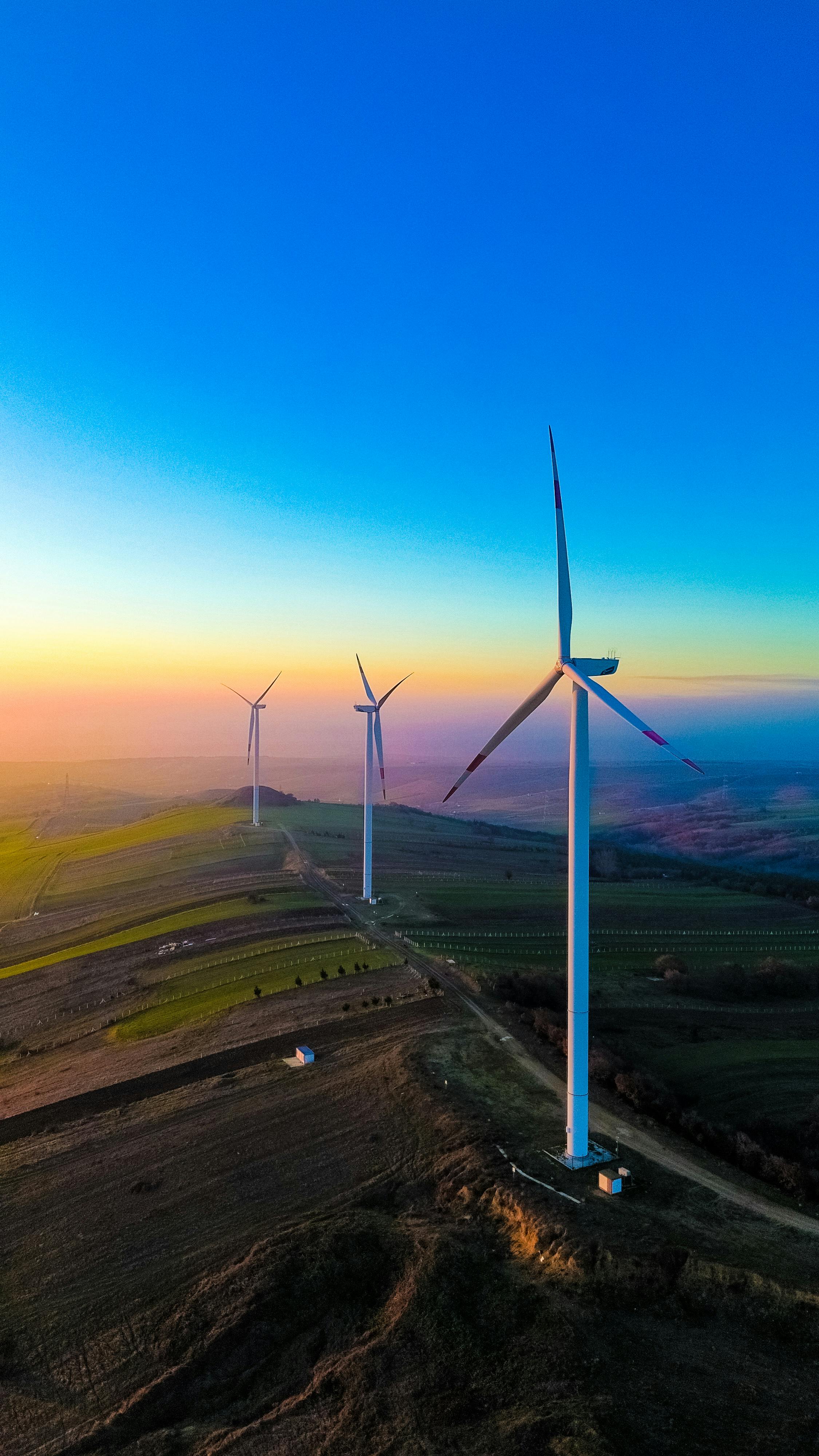 Wind Turbines at Sunset Over Rolling Hills · Free Stock Photo
