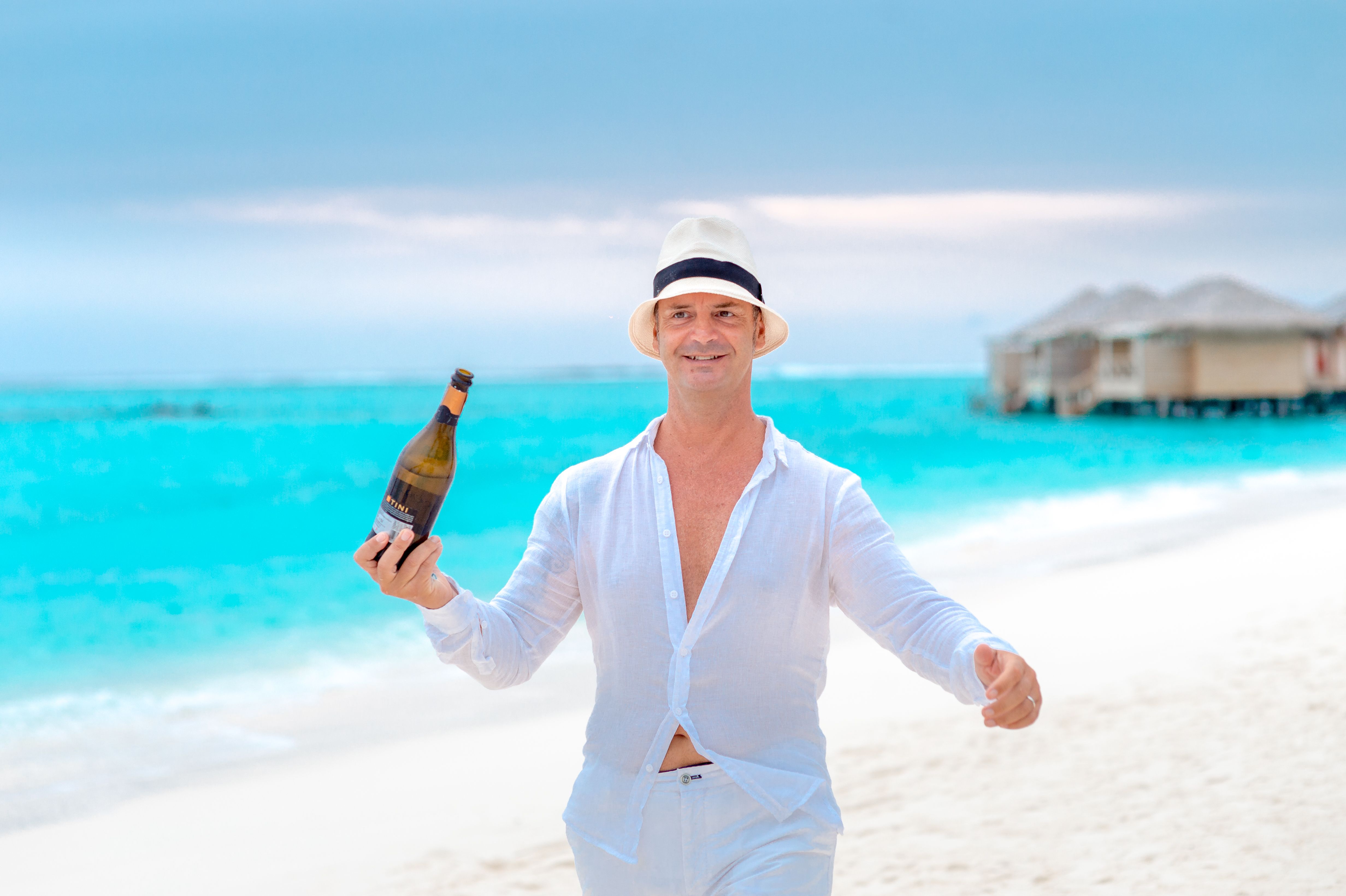 Man Enjoying Beach Vacation with Champagne · Free Stock Photo