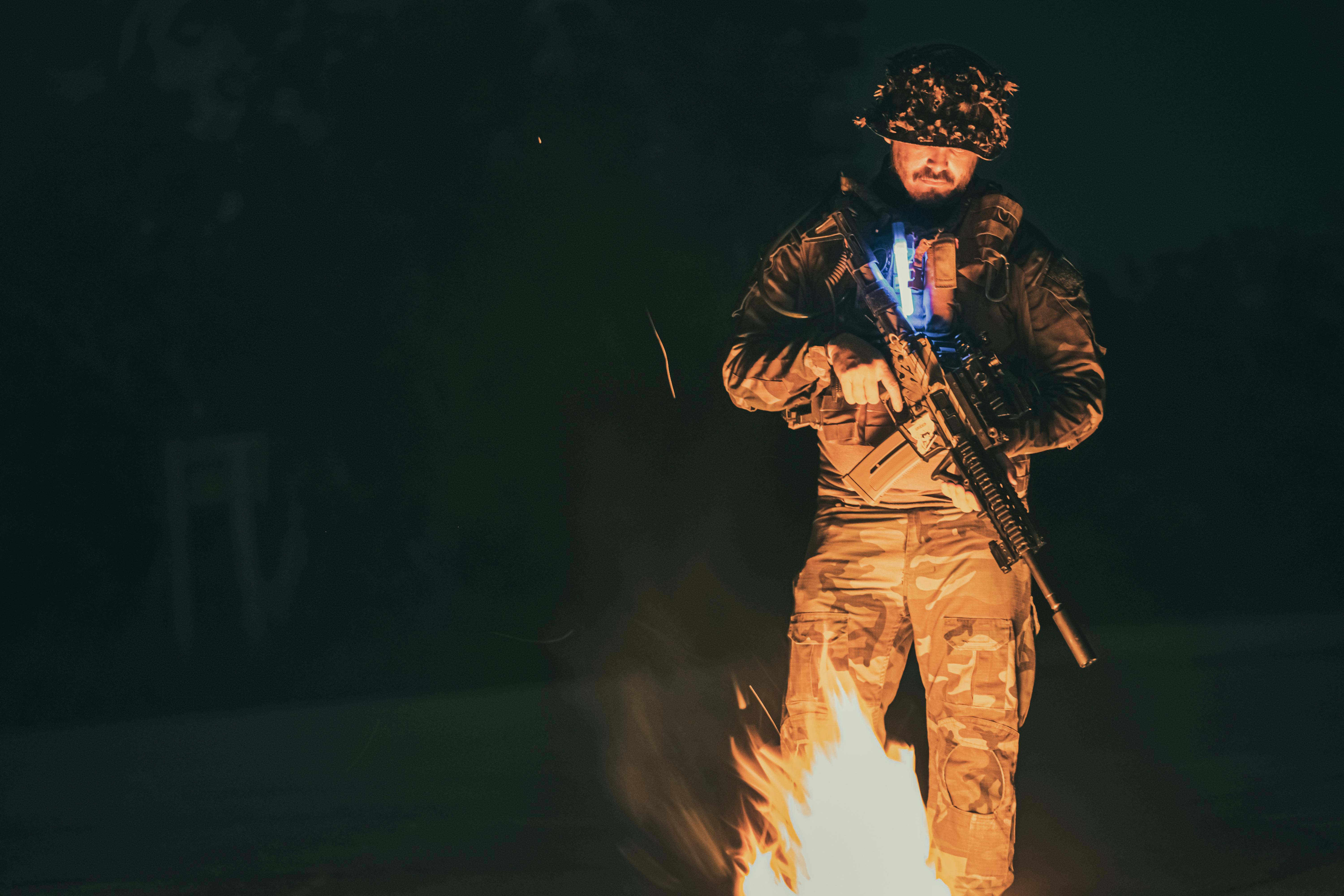 Soldier Standing in Front of Campfire at Night · Free Stock Photo