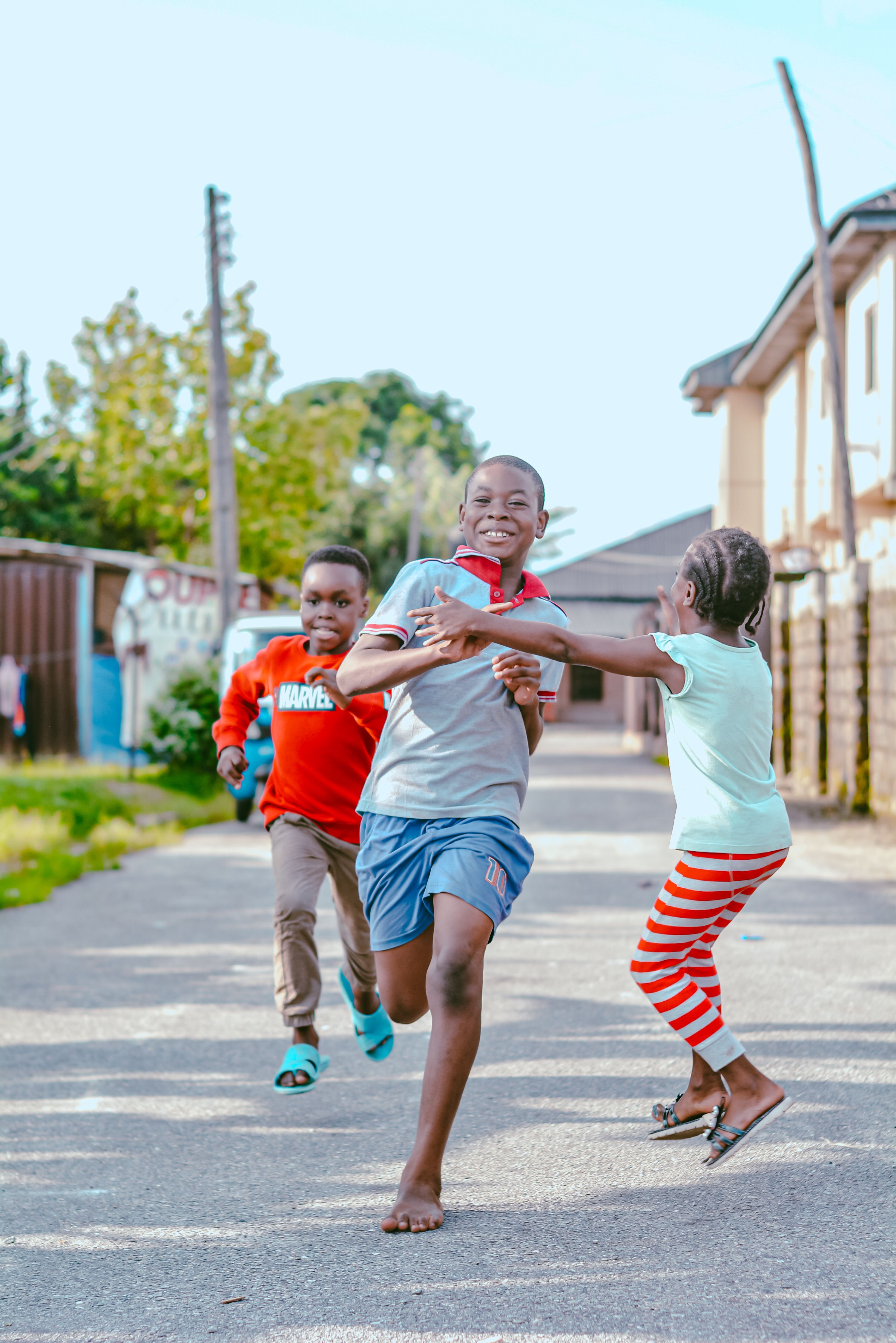 Joyful Kids Playing Outdoors in Vibrant Neighborhood · Free Stock Photo