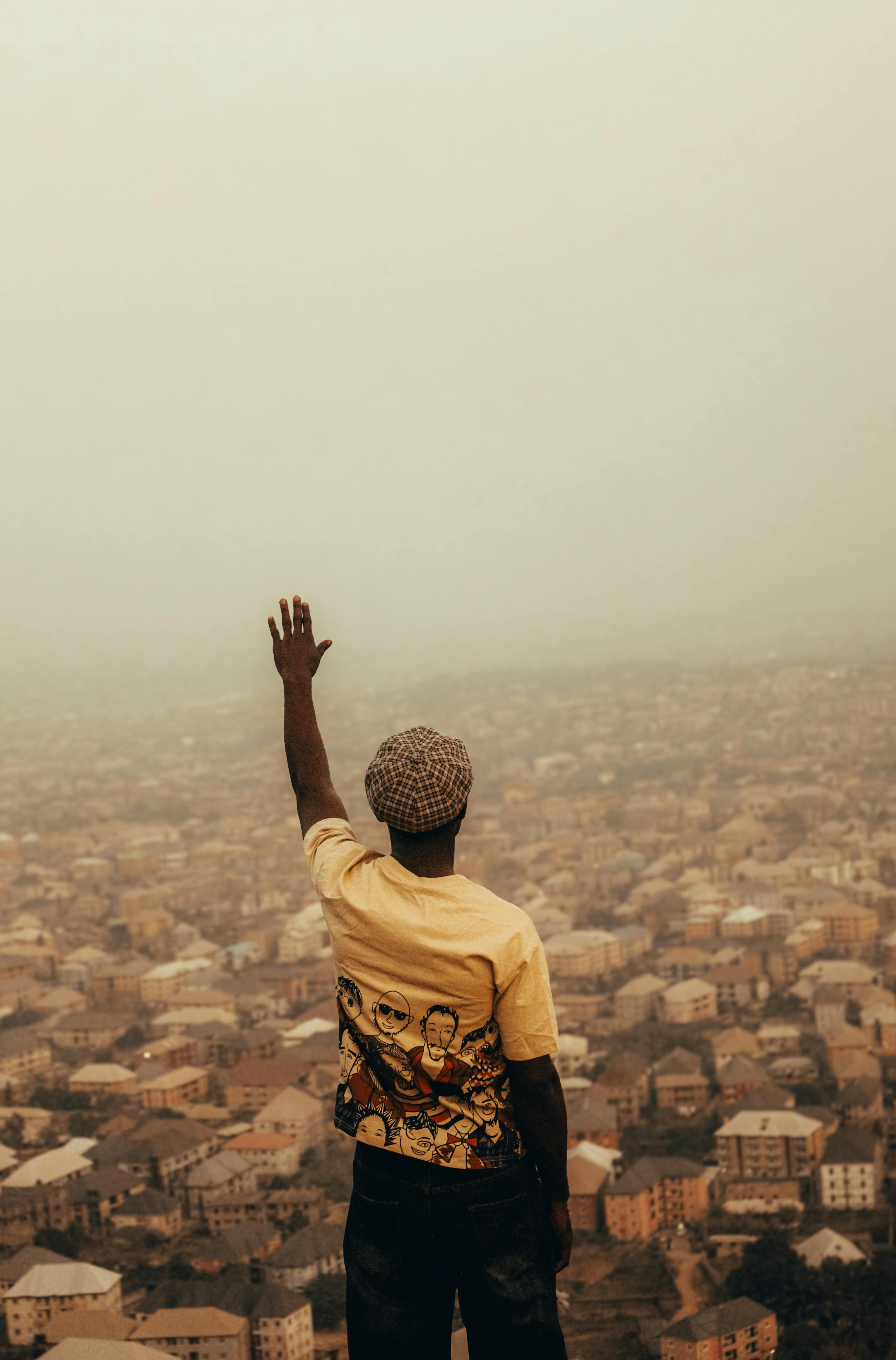 Man Raising Hand Over Enugu Cityscape · Free Stock Photo