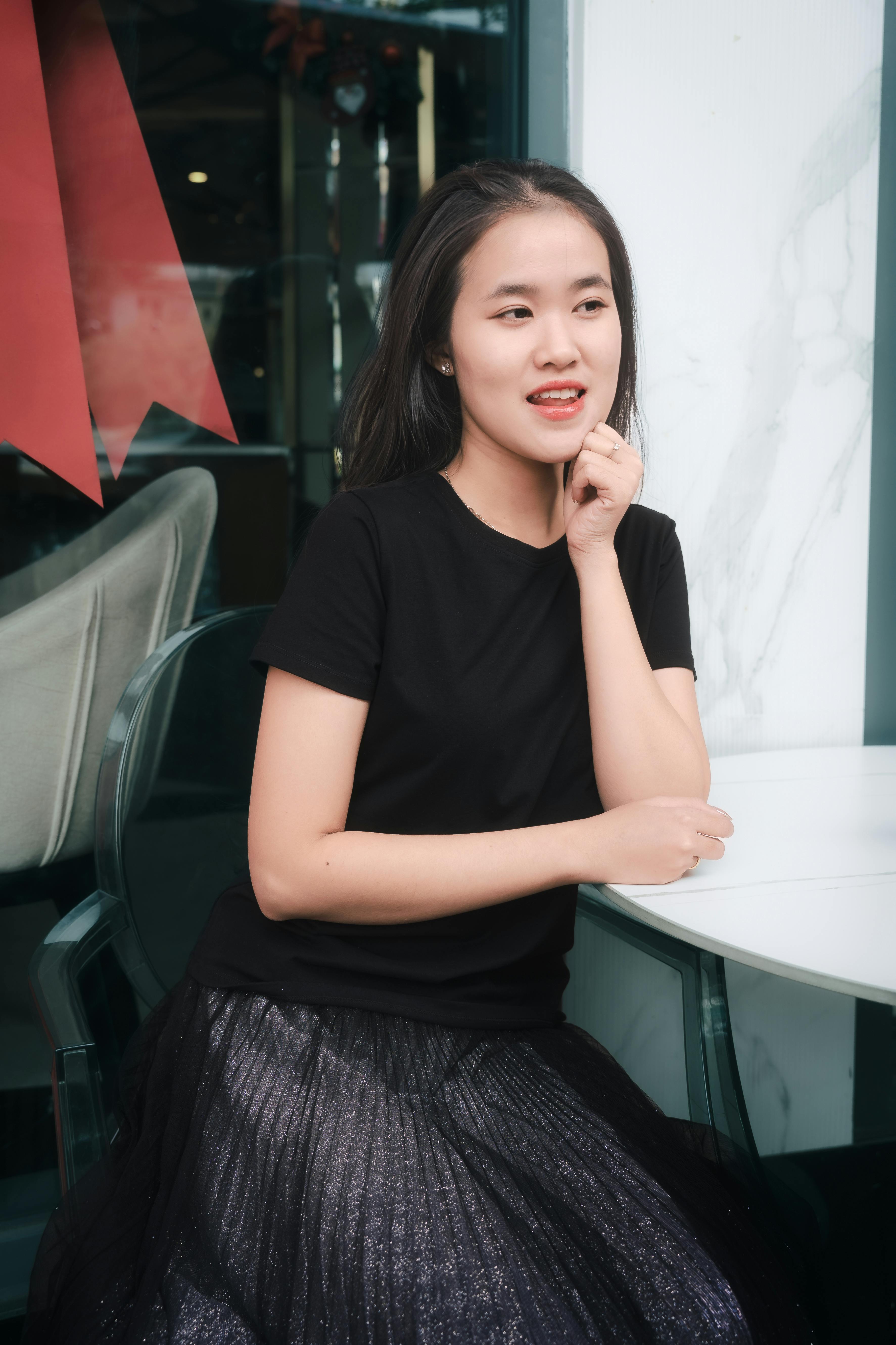 Young Woman Relaxing at a Cafe Table Outdoors · Free Stock Photo