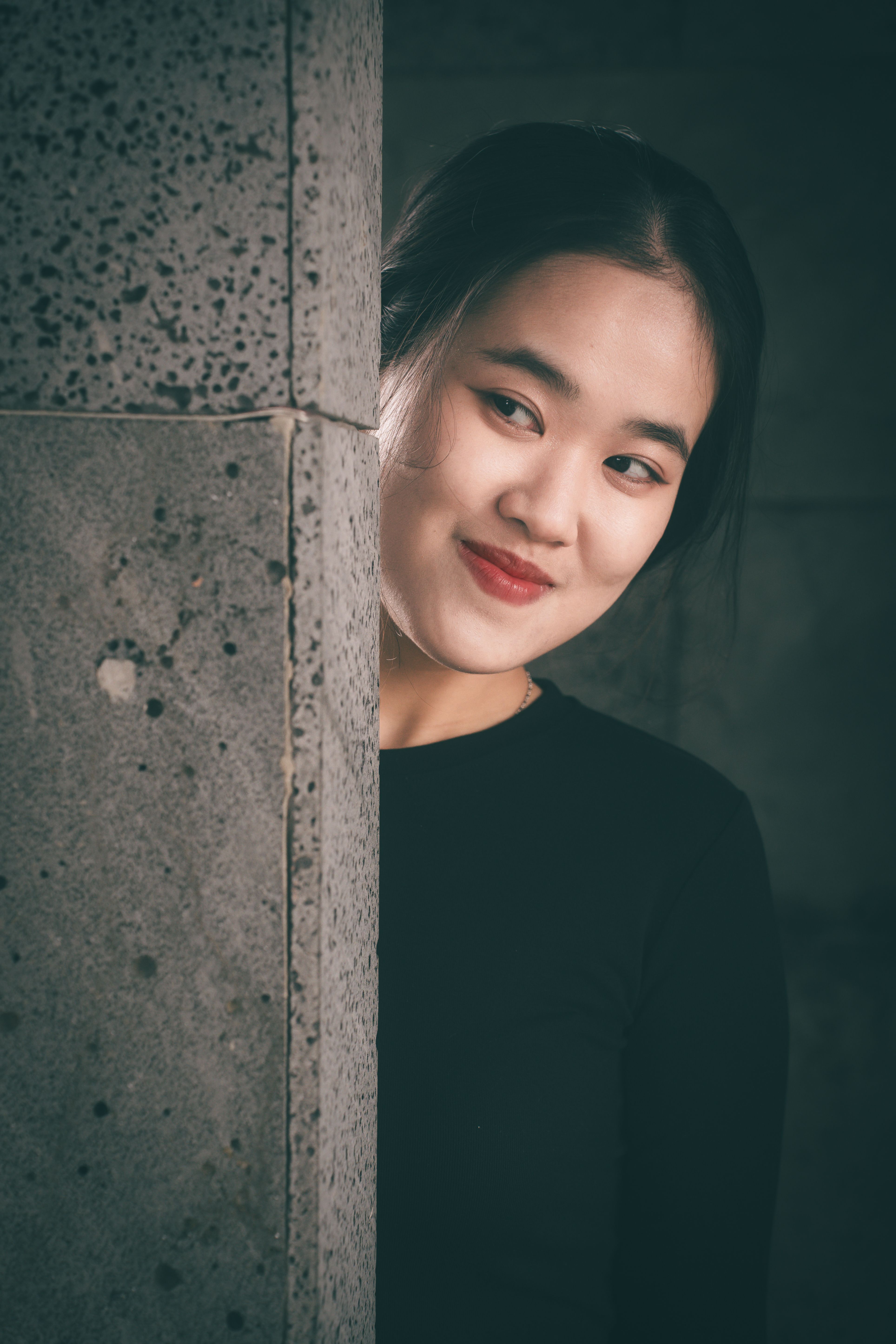 Woman in Black Top Peeking Around a Corner · Free Stock Photo