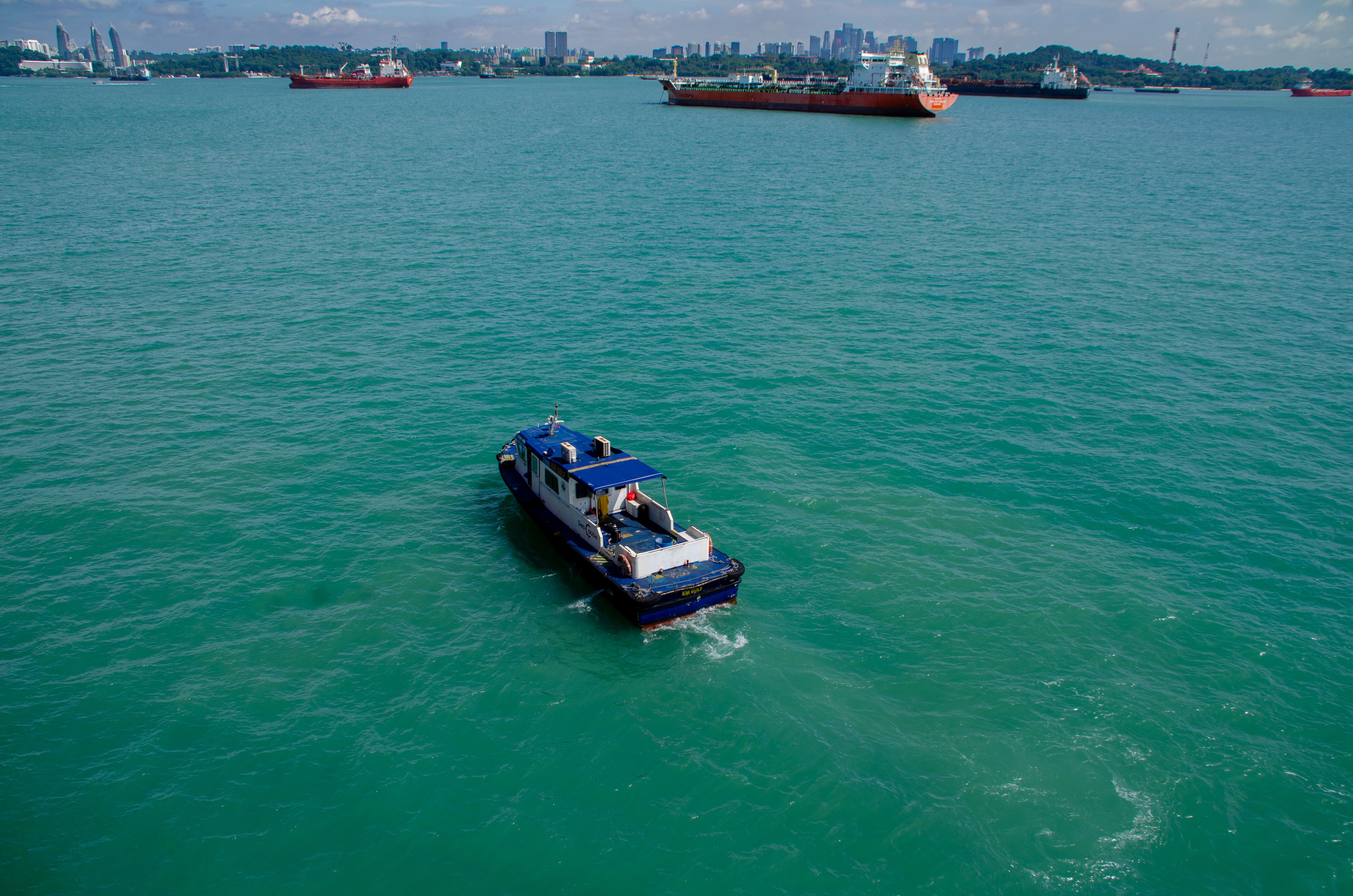 Small Boat in Busy Shipping Channel · Free Stock Photo