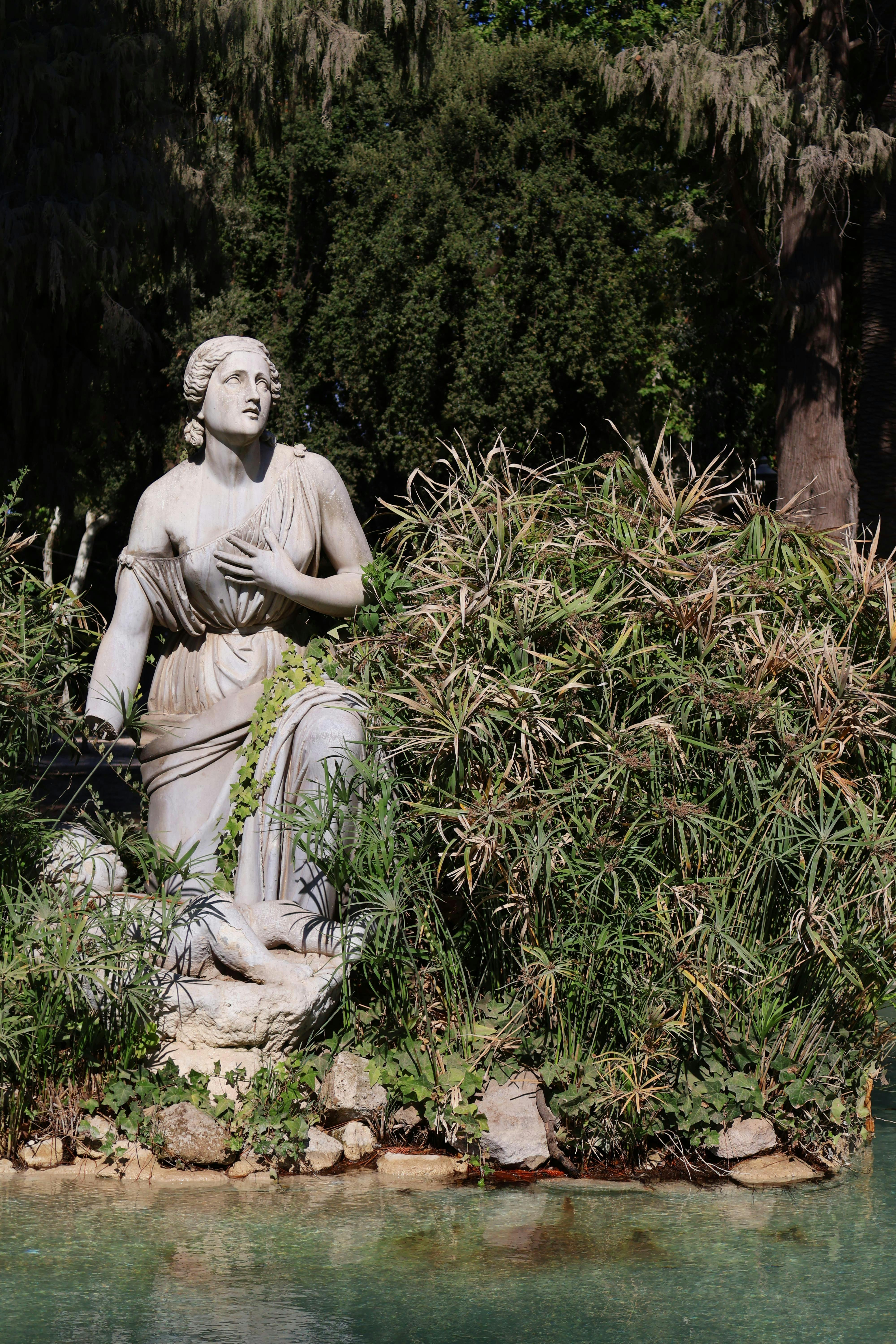 Classical Statue Surrounded by Lush Vegetation in Rome · Free Stock Photo