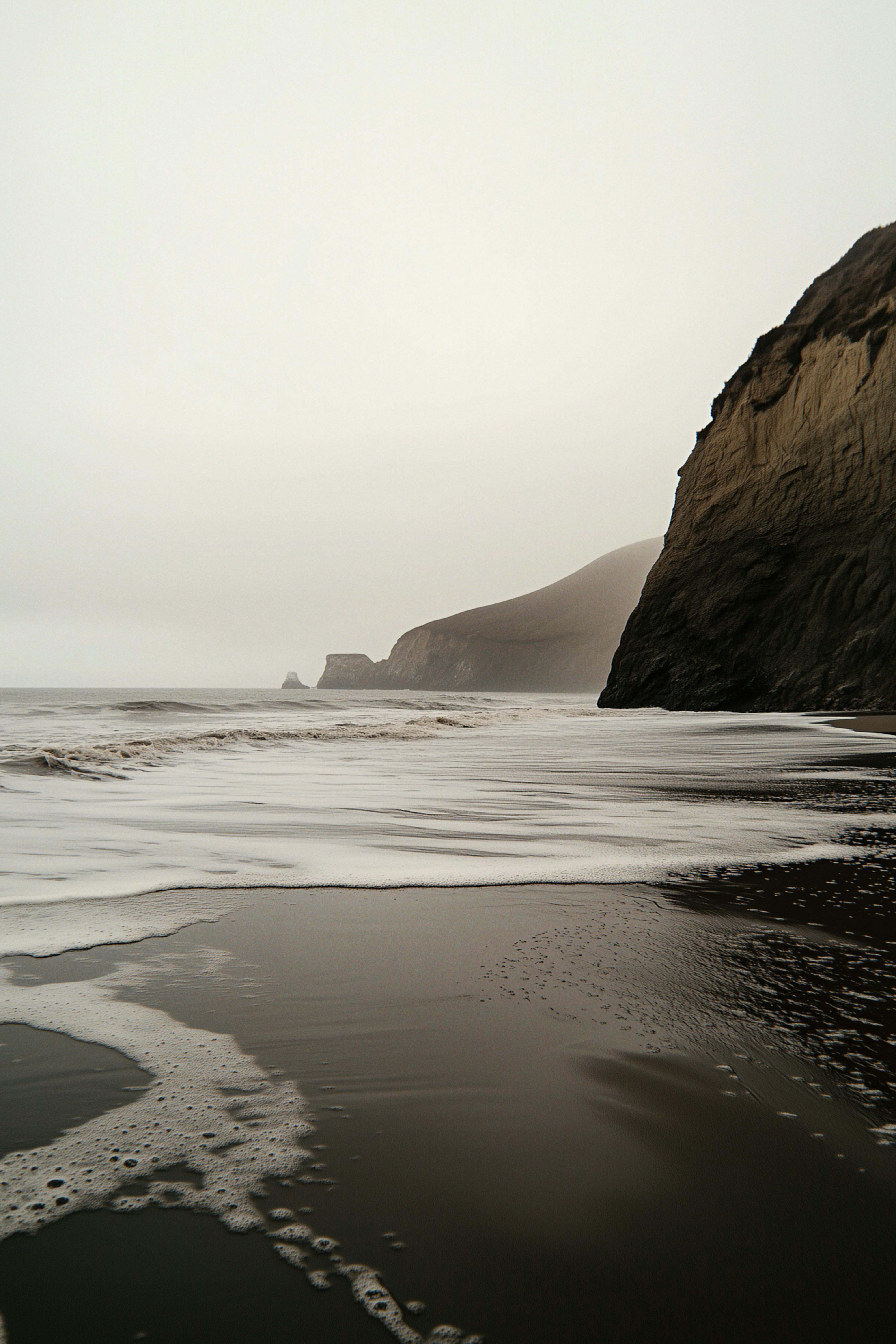 Dramatic Cliffside Beach in Moody Weather · Free Stock Photo
