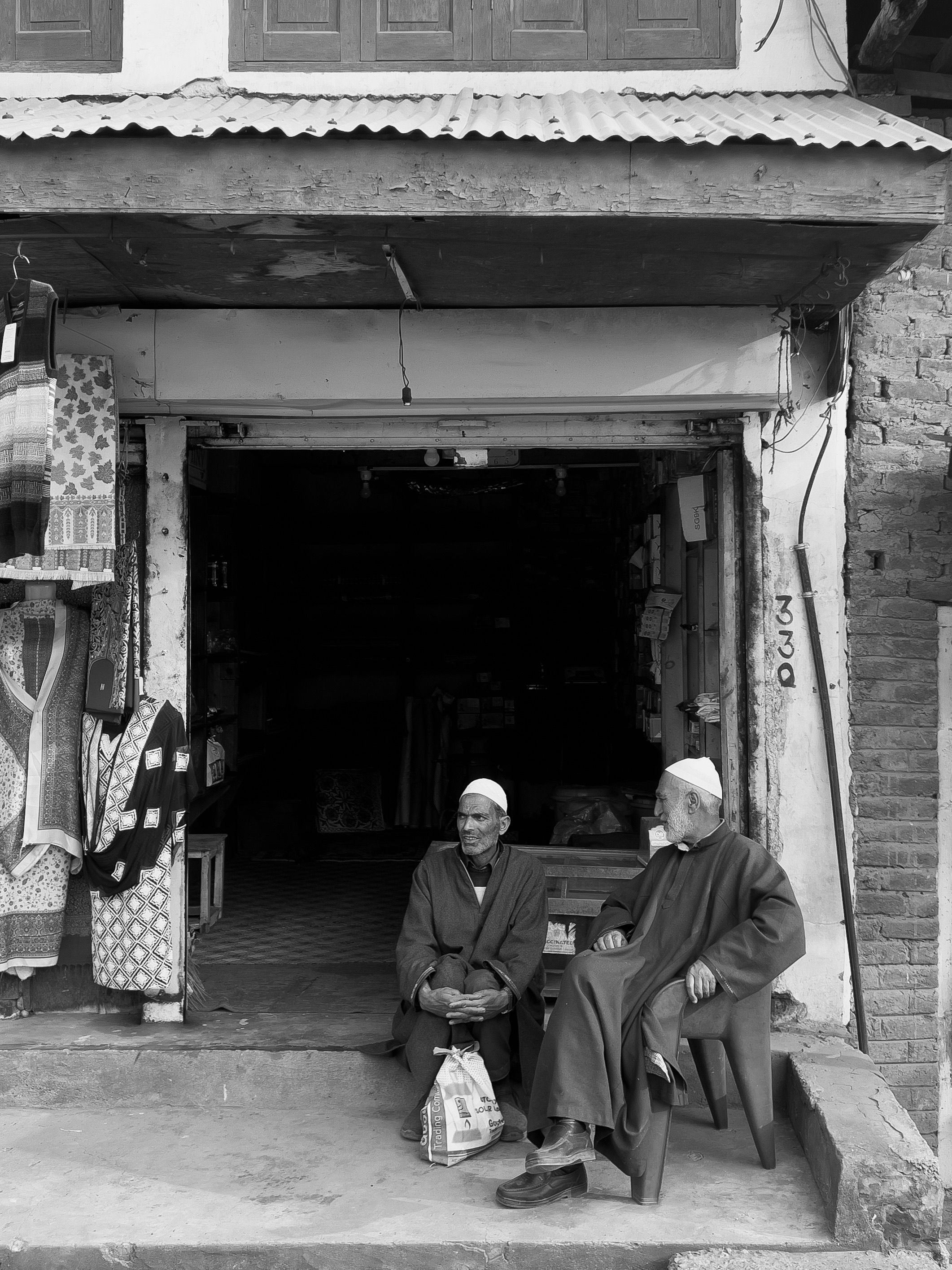 Two Elderly Men Sitting Outside a Traditional Shop · Free Stock Photo