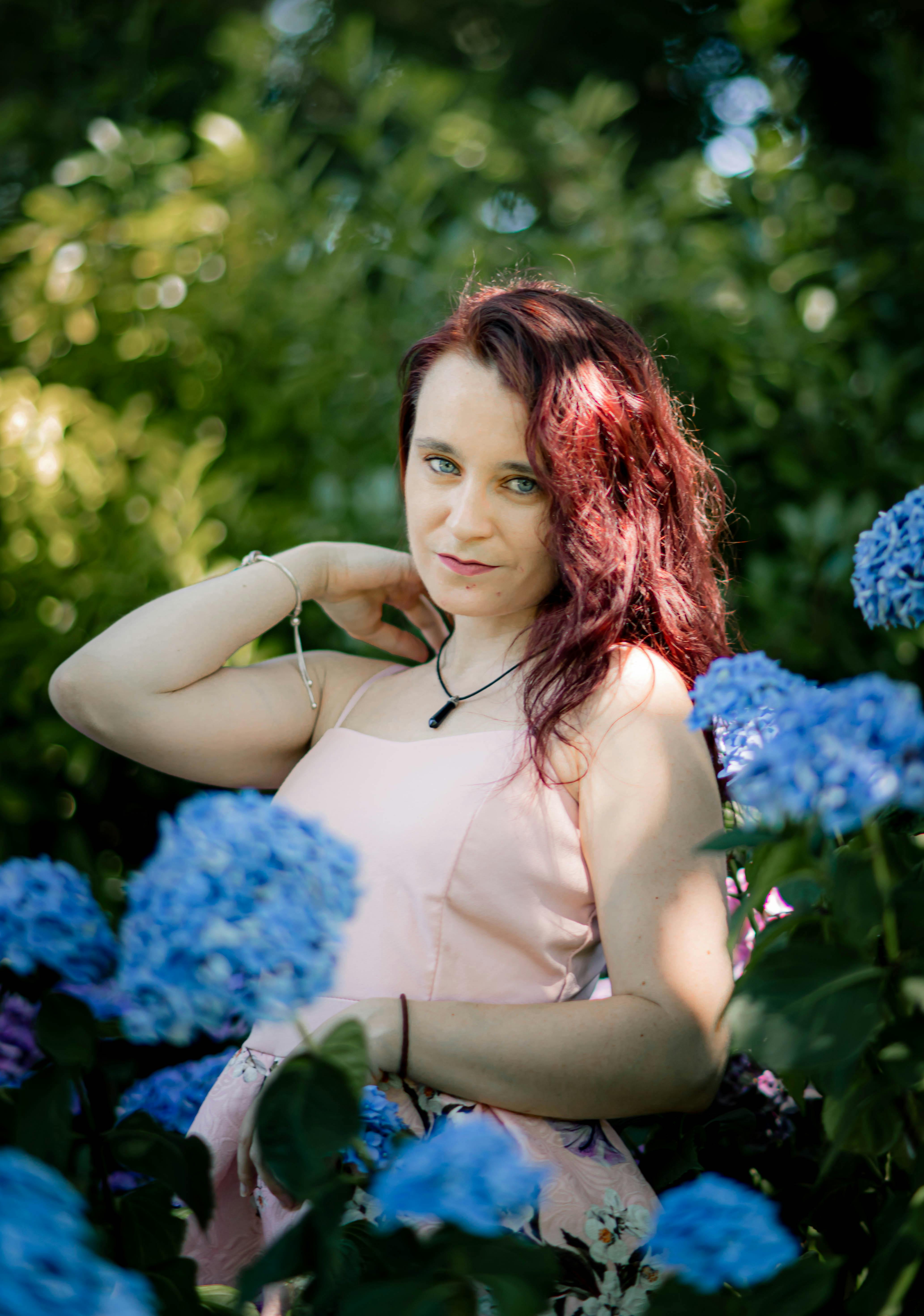 Woman in Pink Dress Among Blue Hydrangeas · Free Stock Photo
