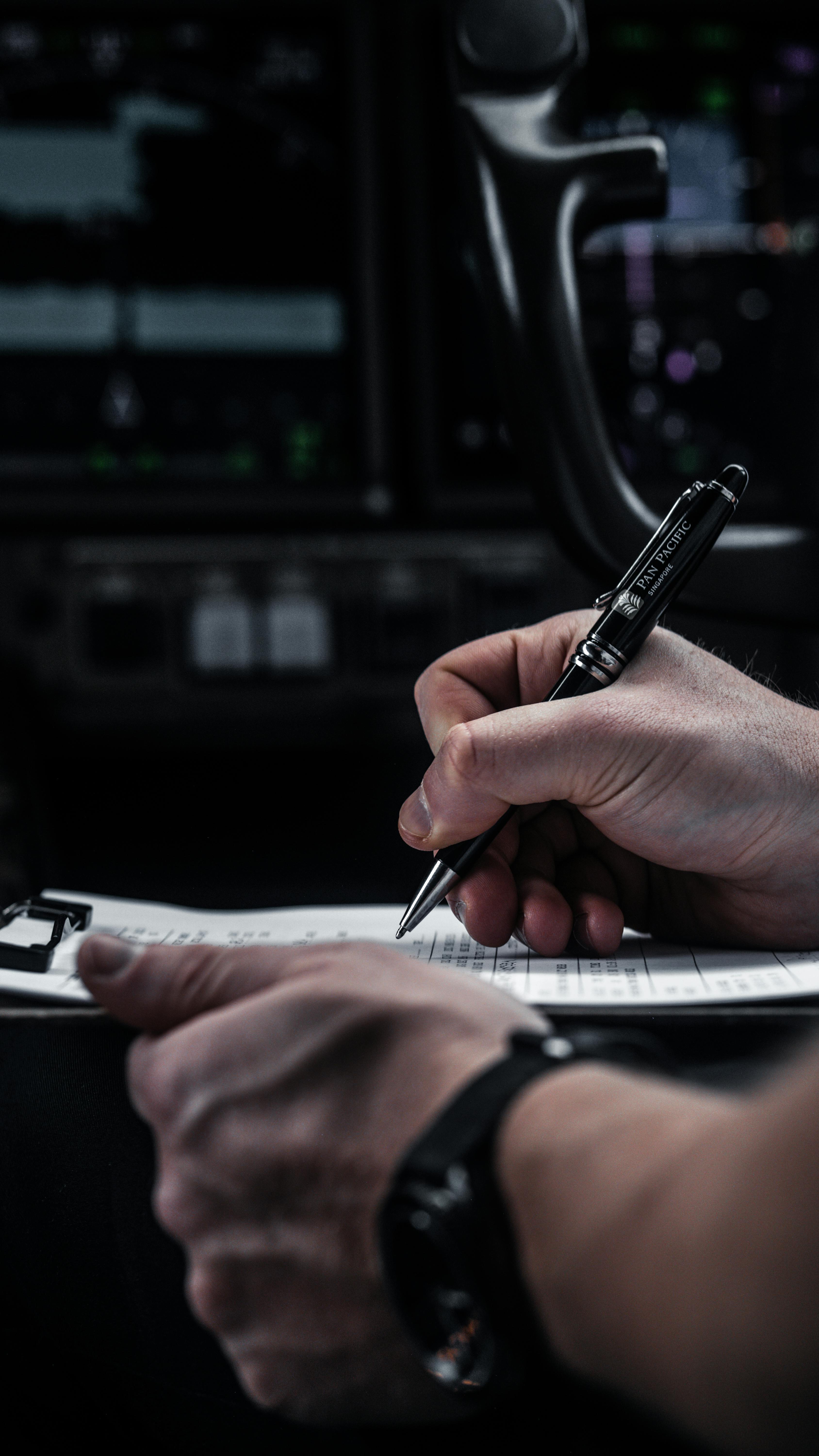 Pilot Completing Paperwork in Aircraft Cockpit · Free Stock Photo