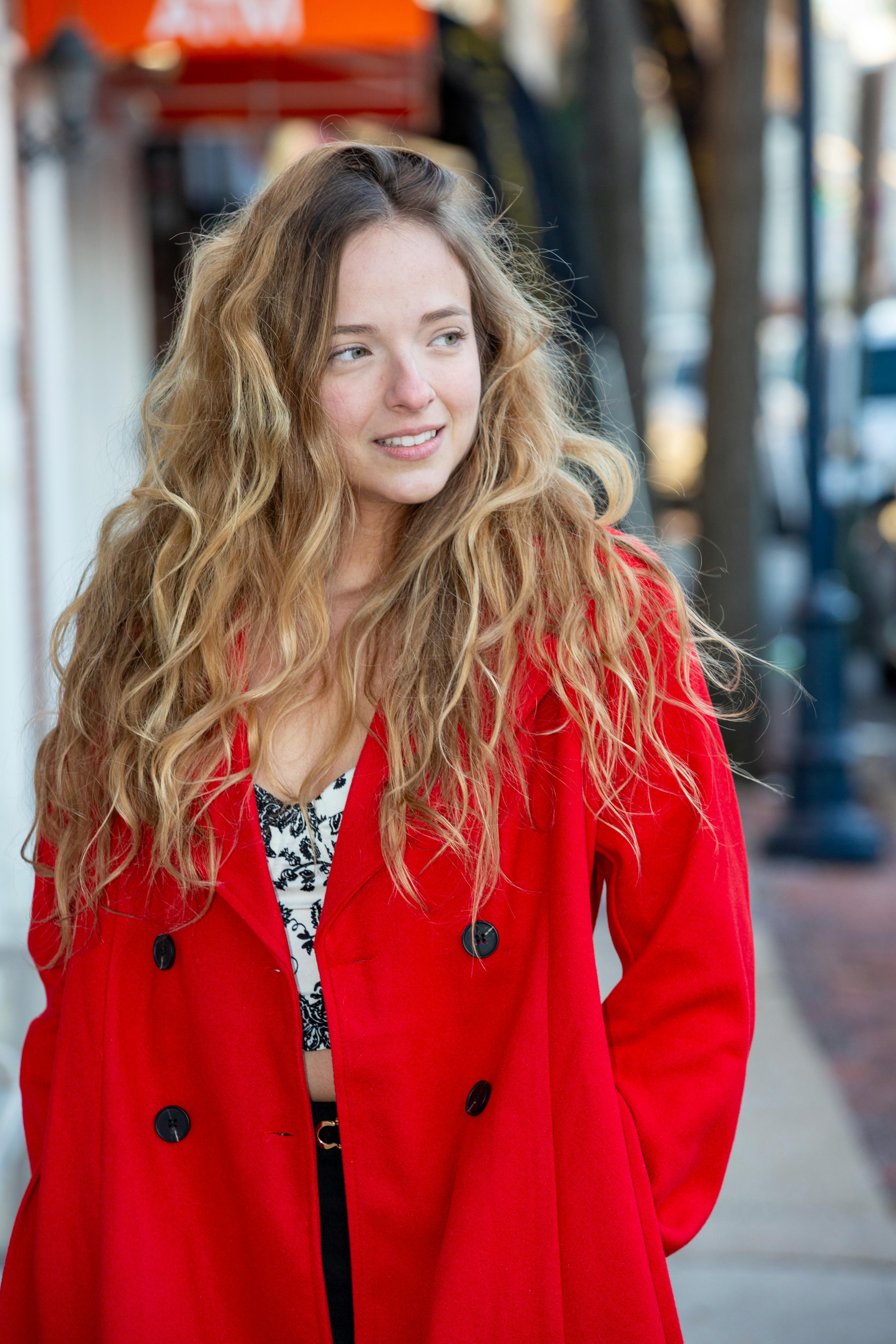 Young Woman in Bright Red Coat on City Street · Free Stock Photo