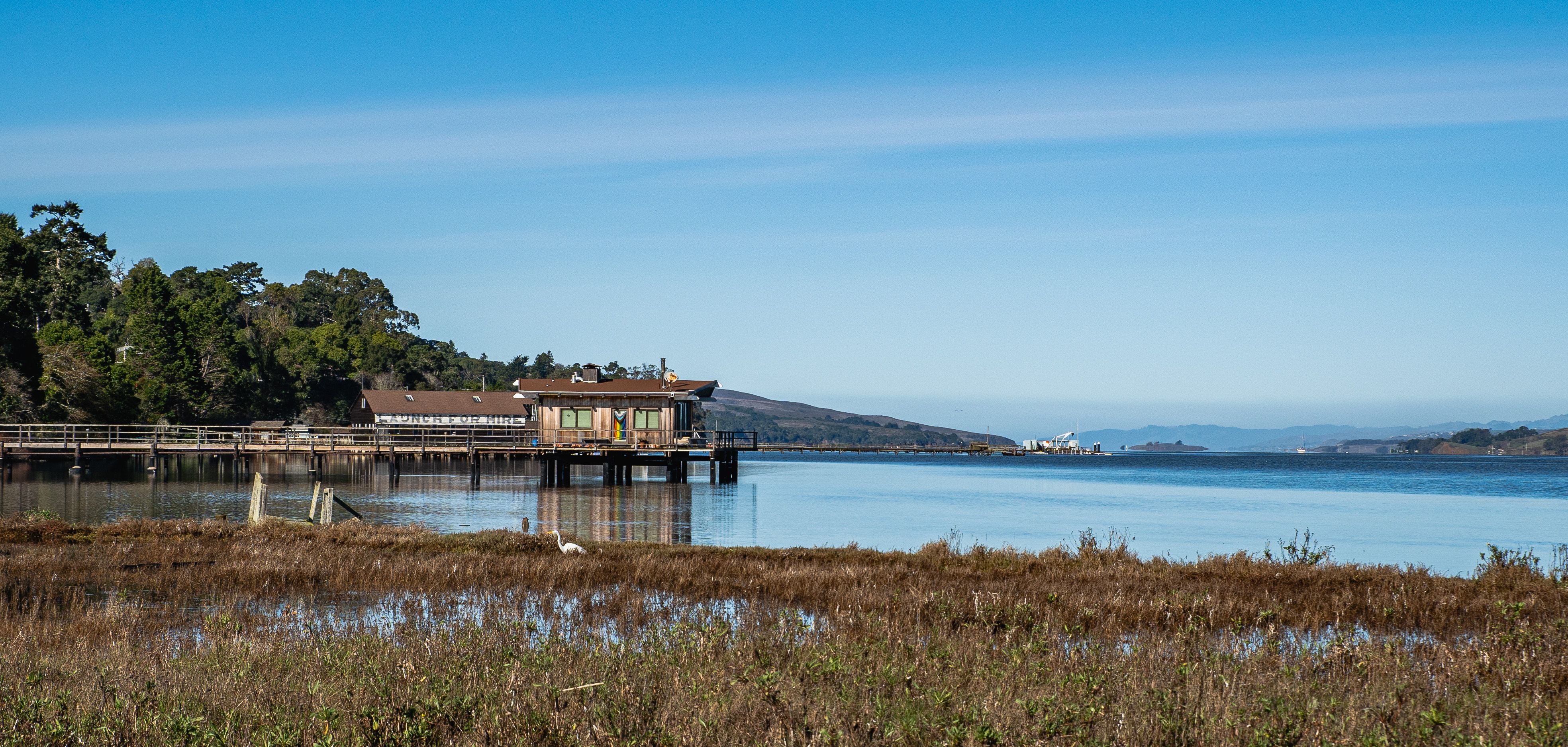 Scenic Waterfront View with Rustic Building and Dock · Free Stock Photo