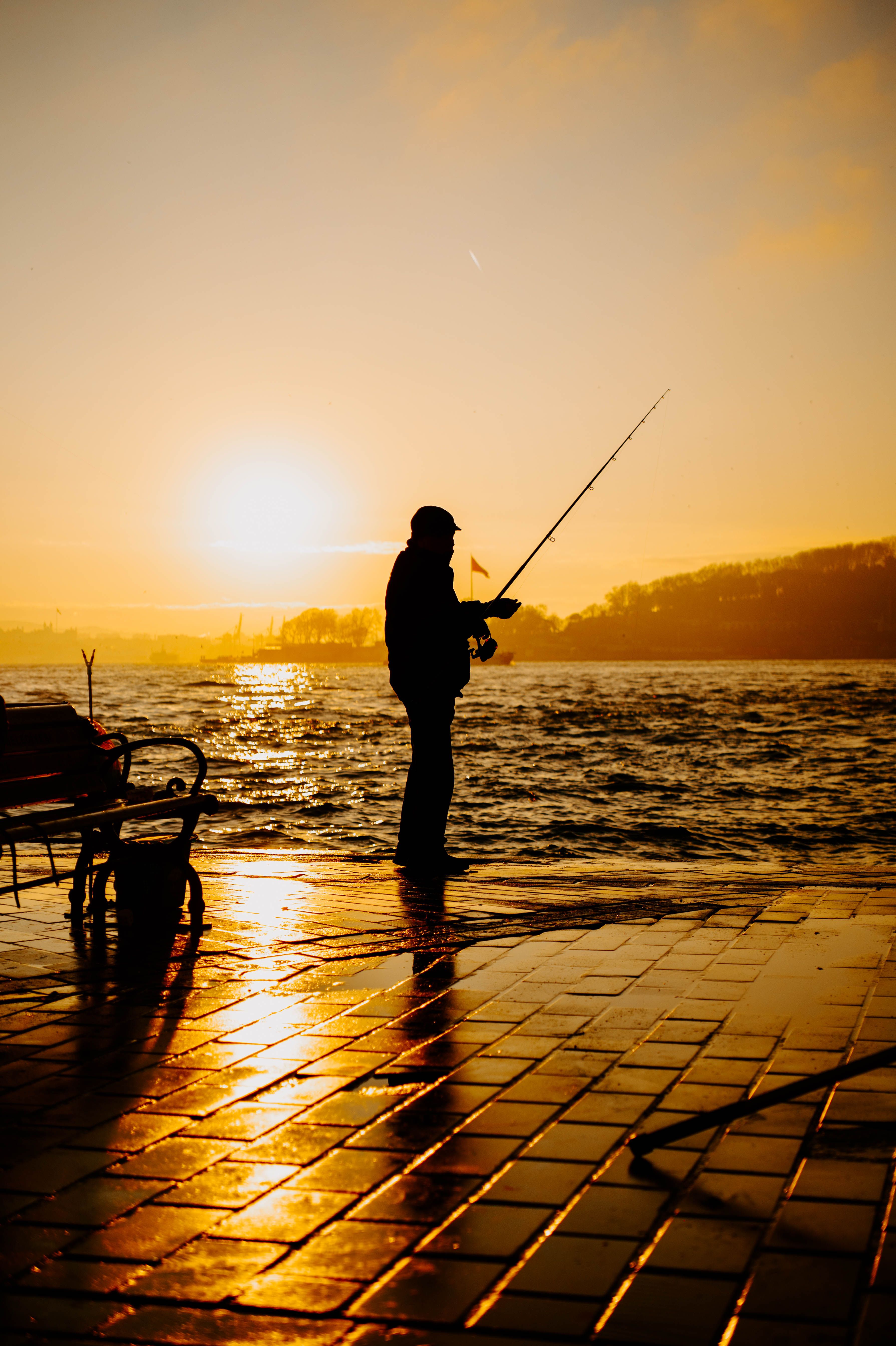 Fisherman at Sunset by the Water's Edge · Free Stock Photo