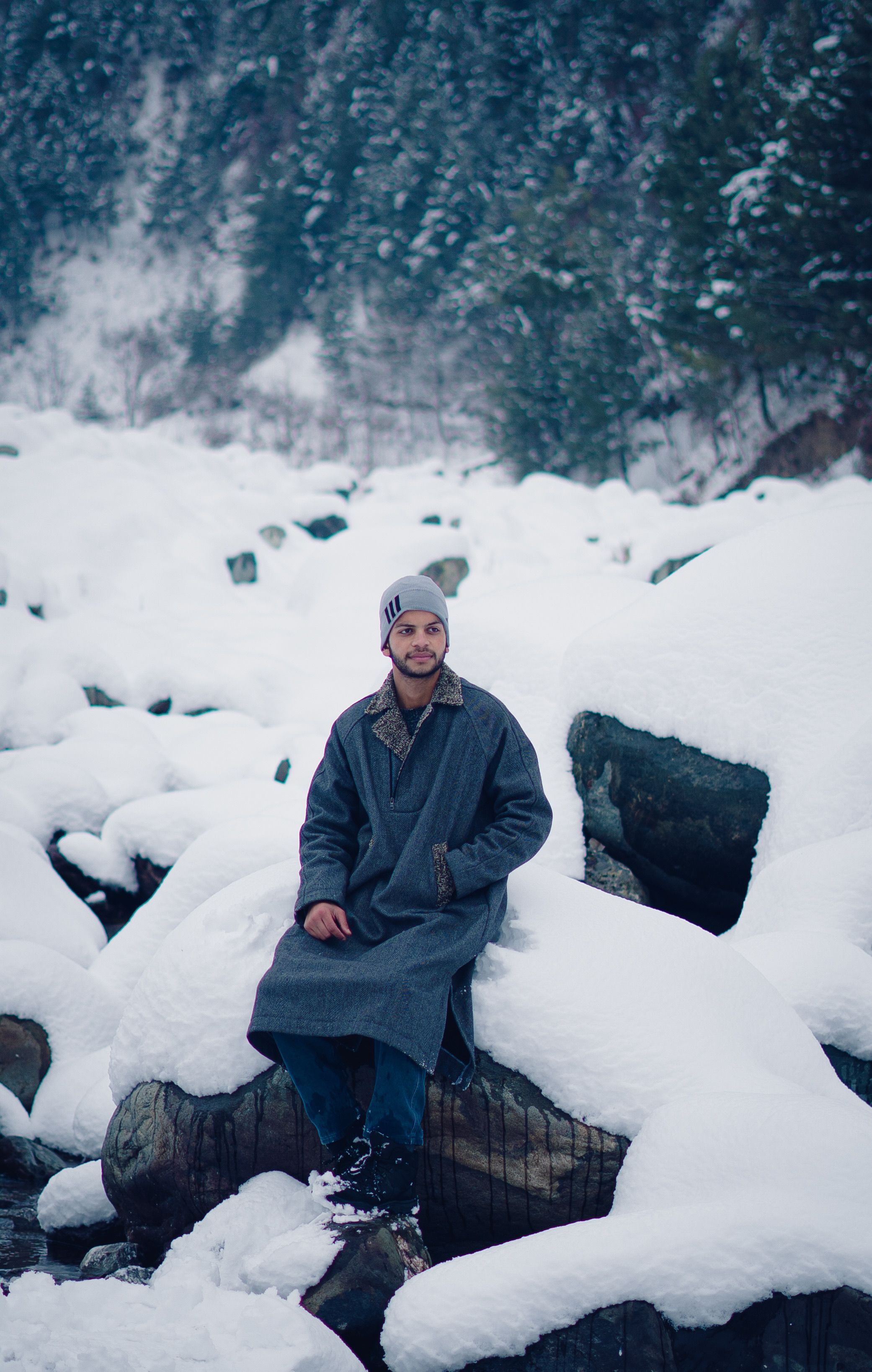 Man Sitting on Snow-Covered Rock in Srinagar · Free Stock Photo