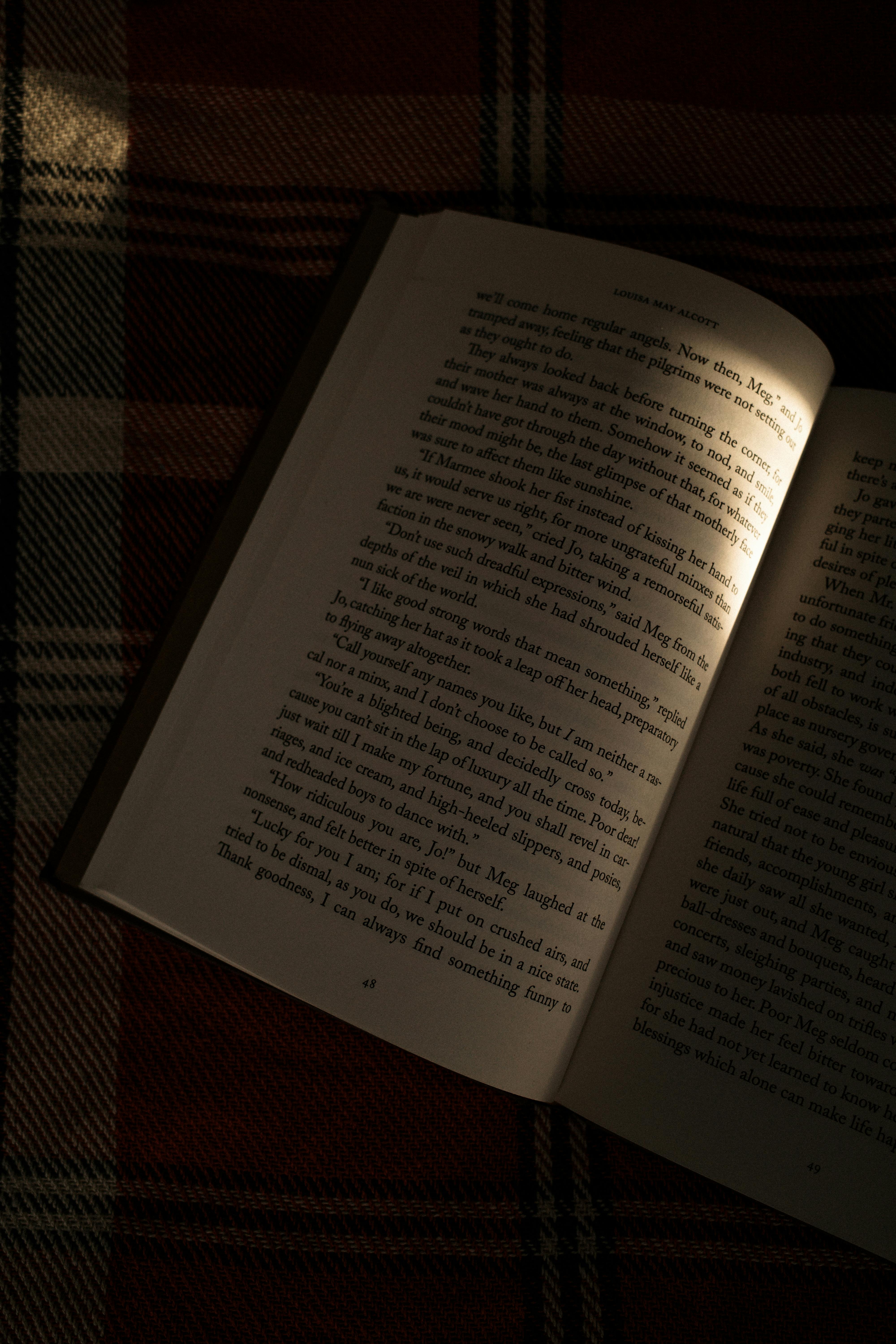 Open Book on Plaid Fabric with Dramatic Lighting · Free Stock Photo