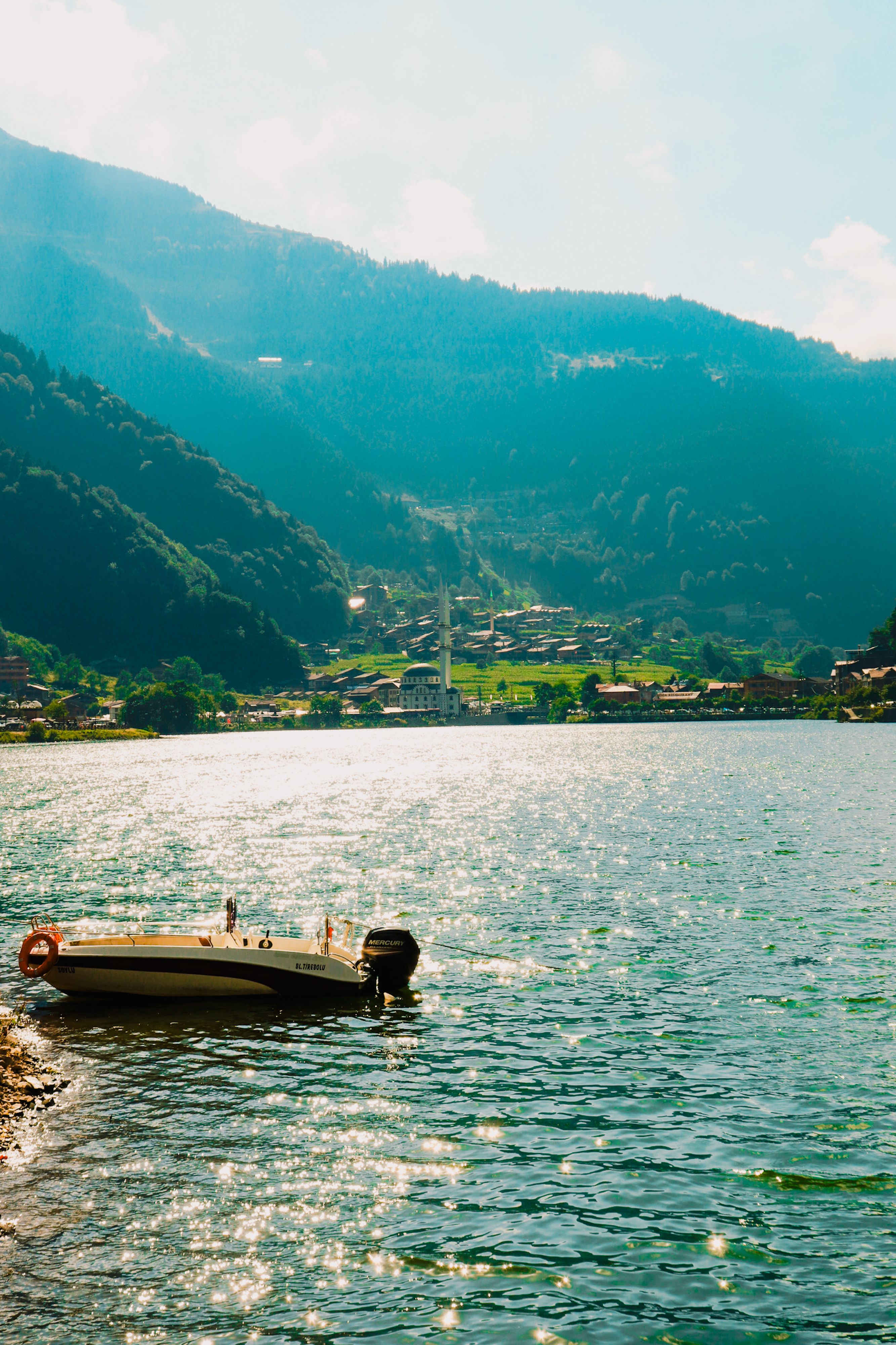 Serene Lakeview in Türkiye with Boat and Mountains · Free Stock Photo
