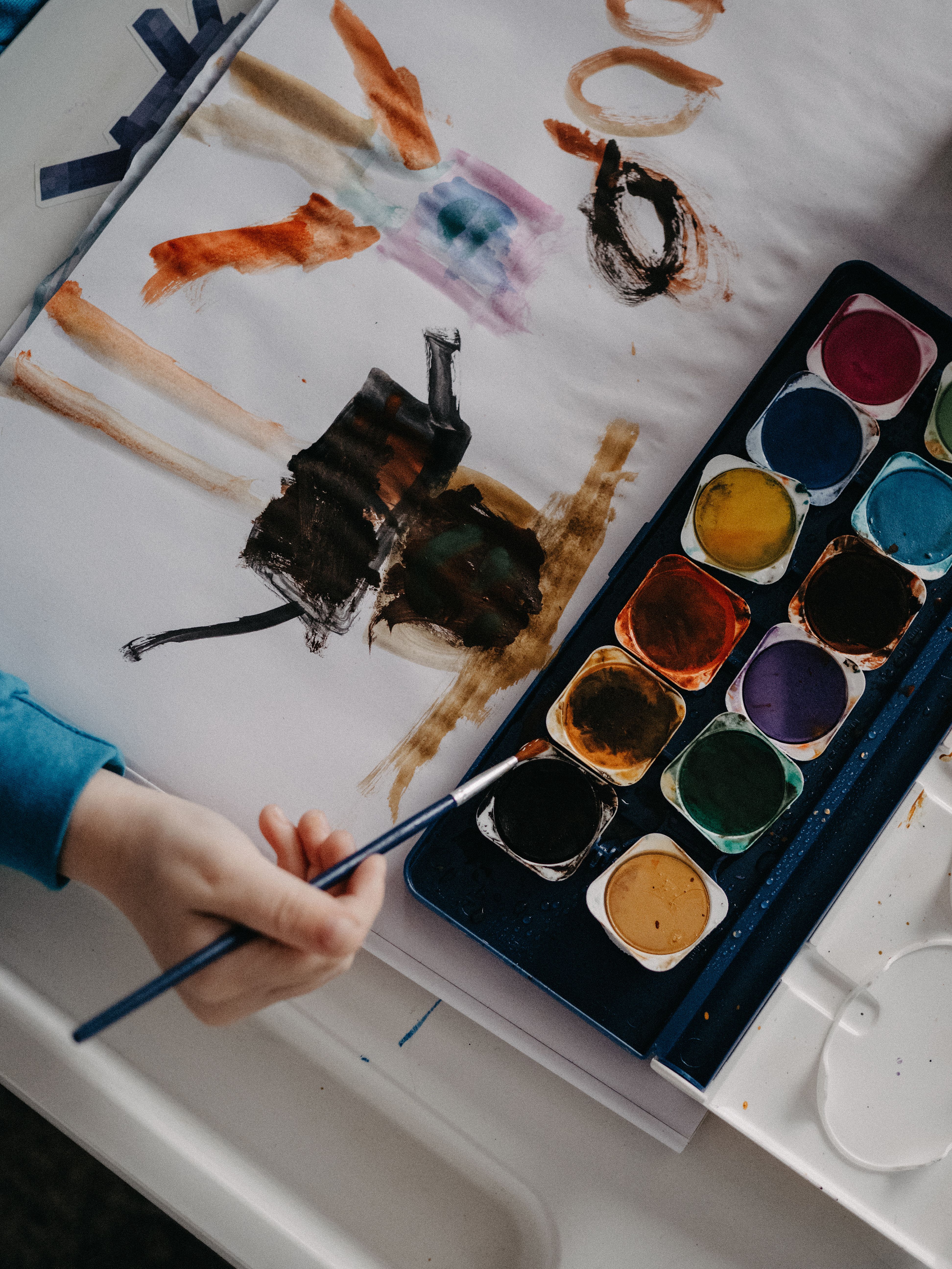 Child Painting with Watercolors in a Creative Setting · Free Stock Photo