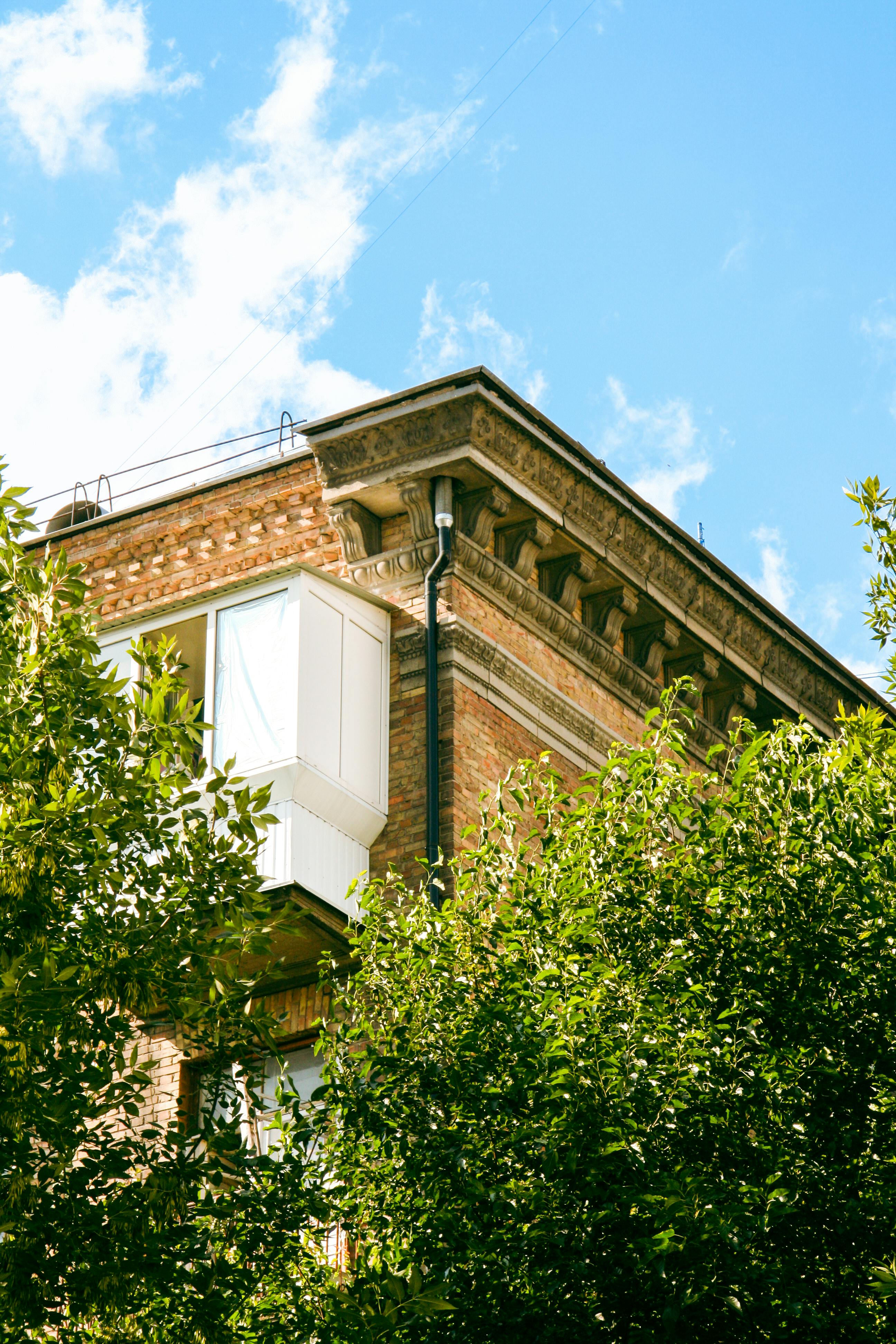 Historic Building Corner with Lush Greenery · Free Stock Photo