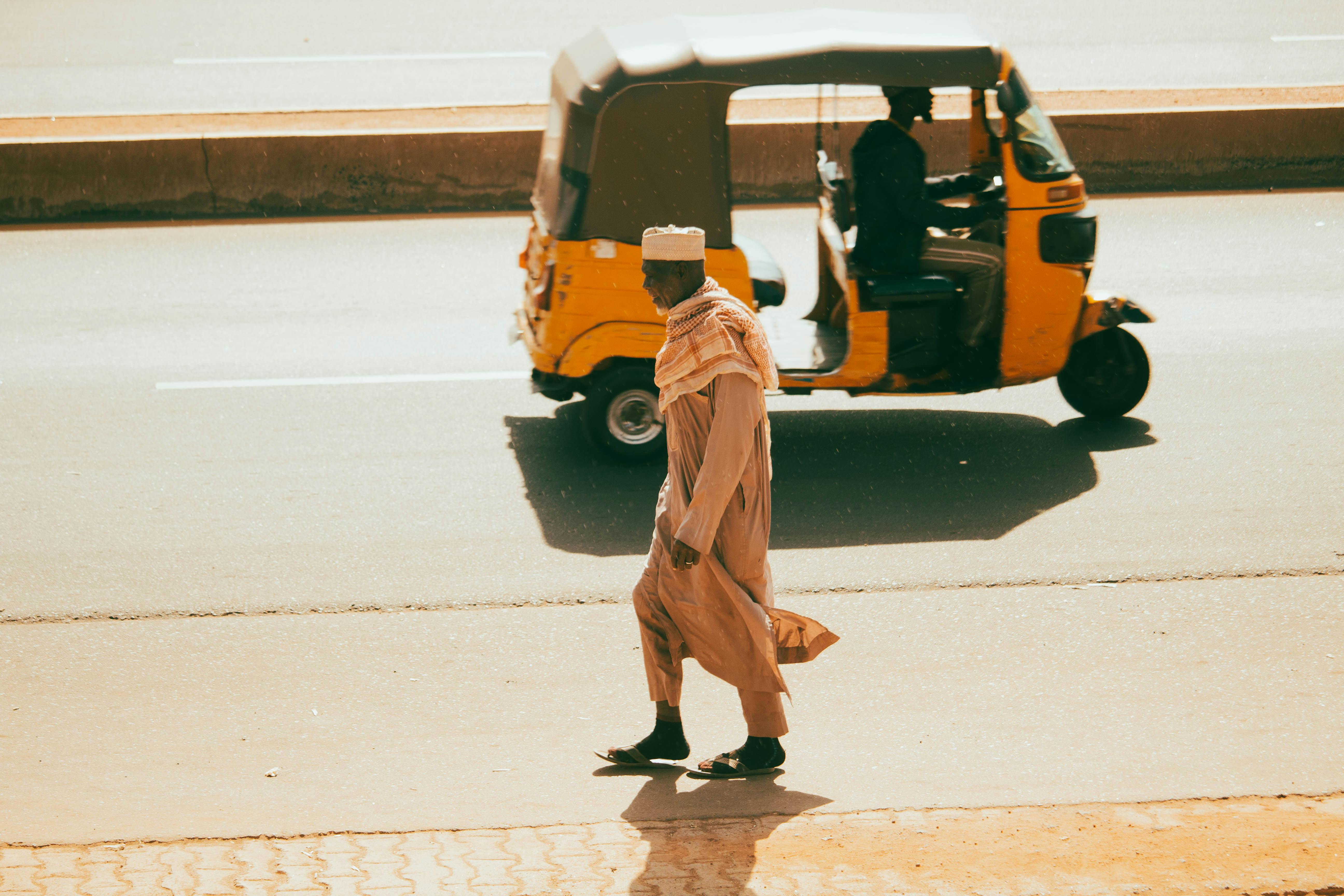 Man Walking by Yellow Auto Rickshaw on Street · Free Stock Photo