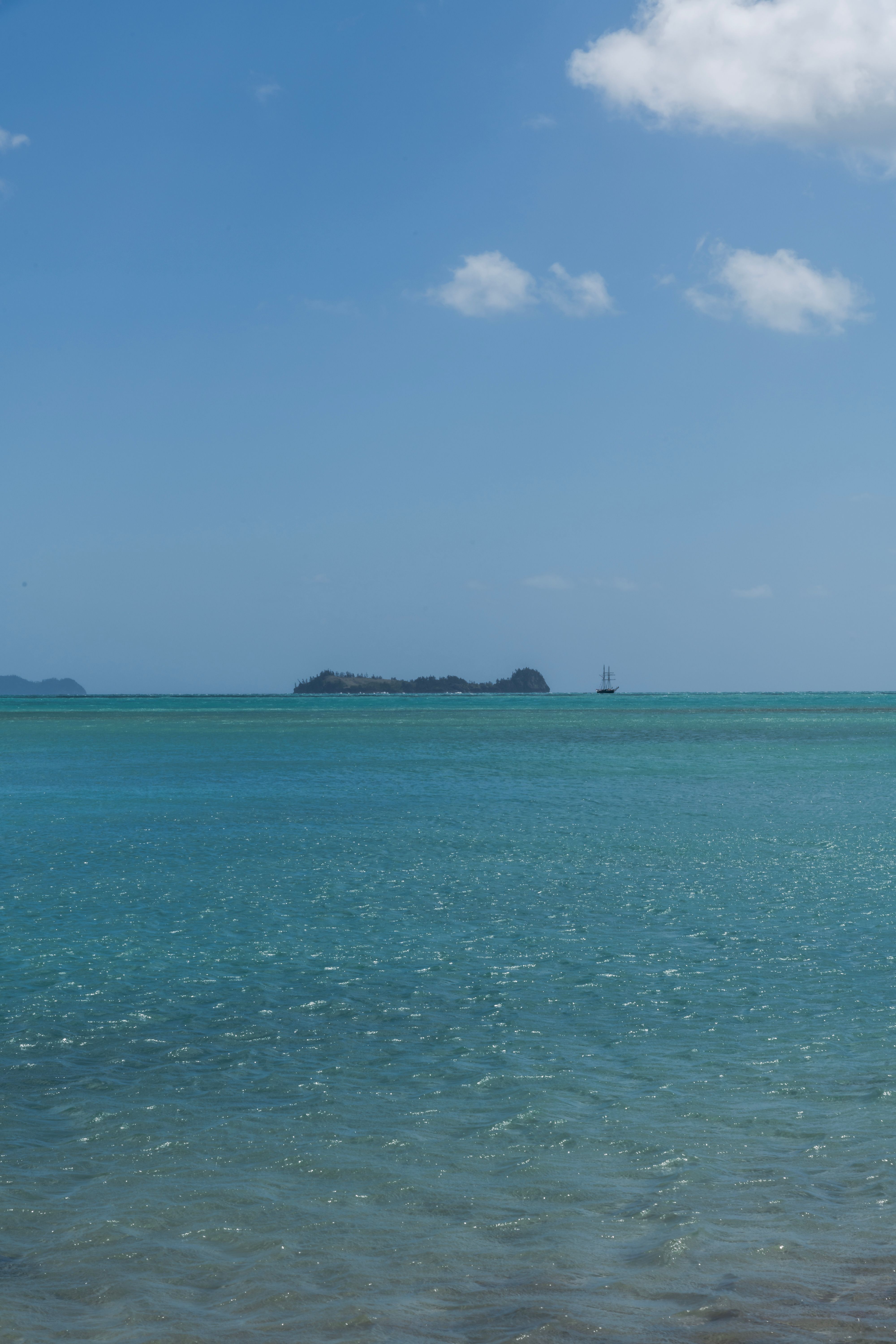 Laut Biru Yang Tenang Dengan Pemandangan Pulau Yang Jauh · Foto Stok Gratis
