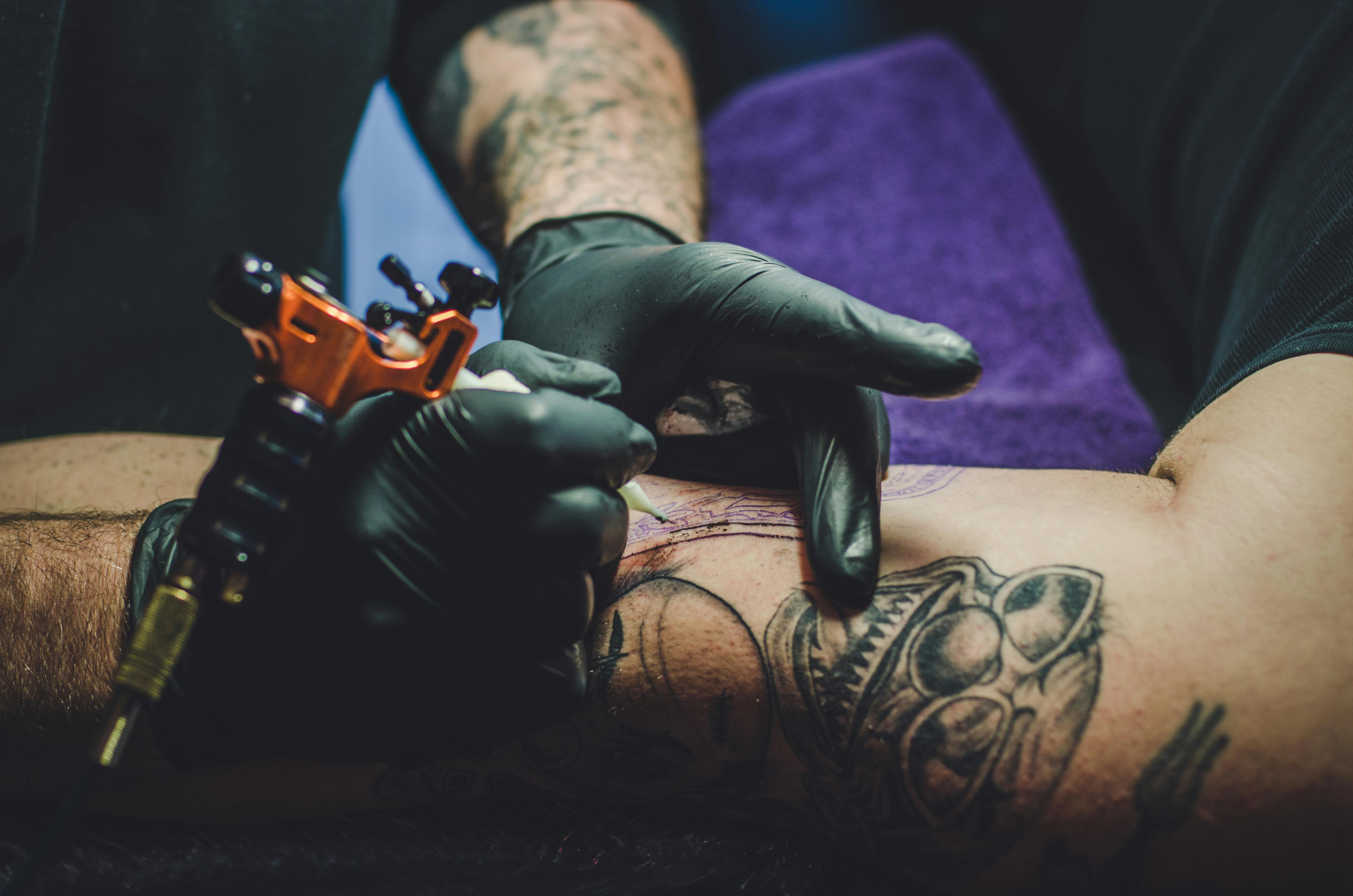 Professional Tattoo Artist Working on Intricate Design · Free Stock Photo
