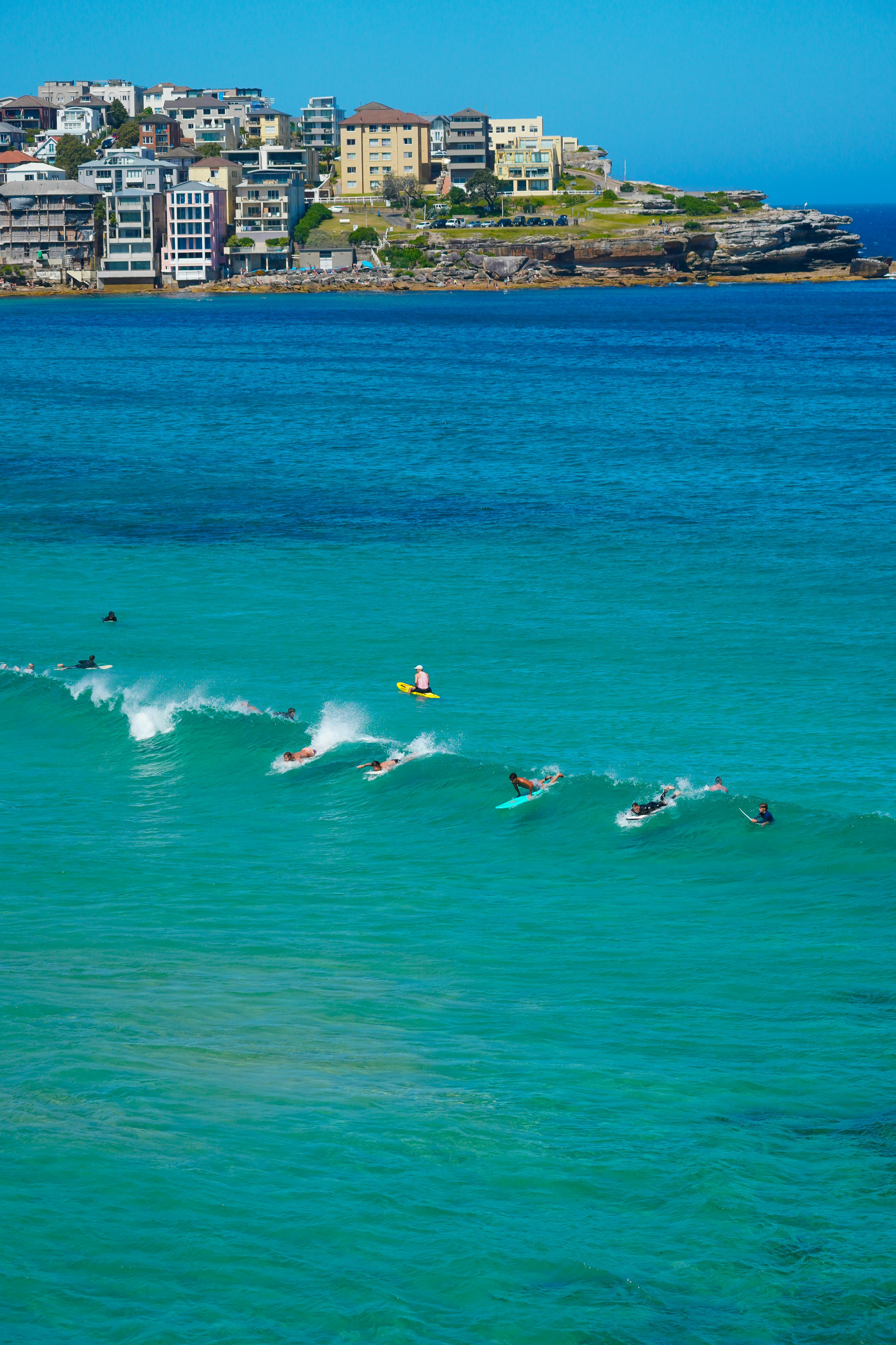 Surfers Riding Waves at Scenic Beachfront · Free Stock Photo