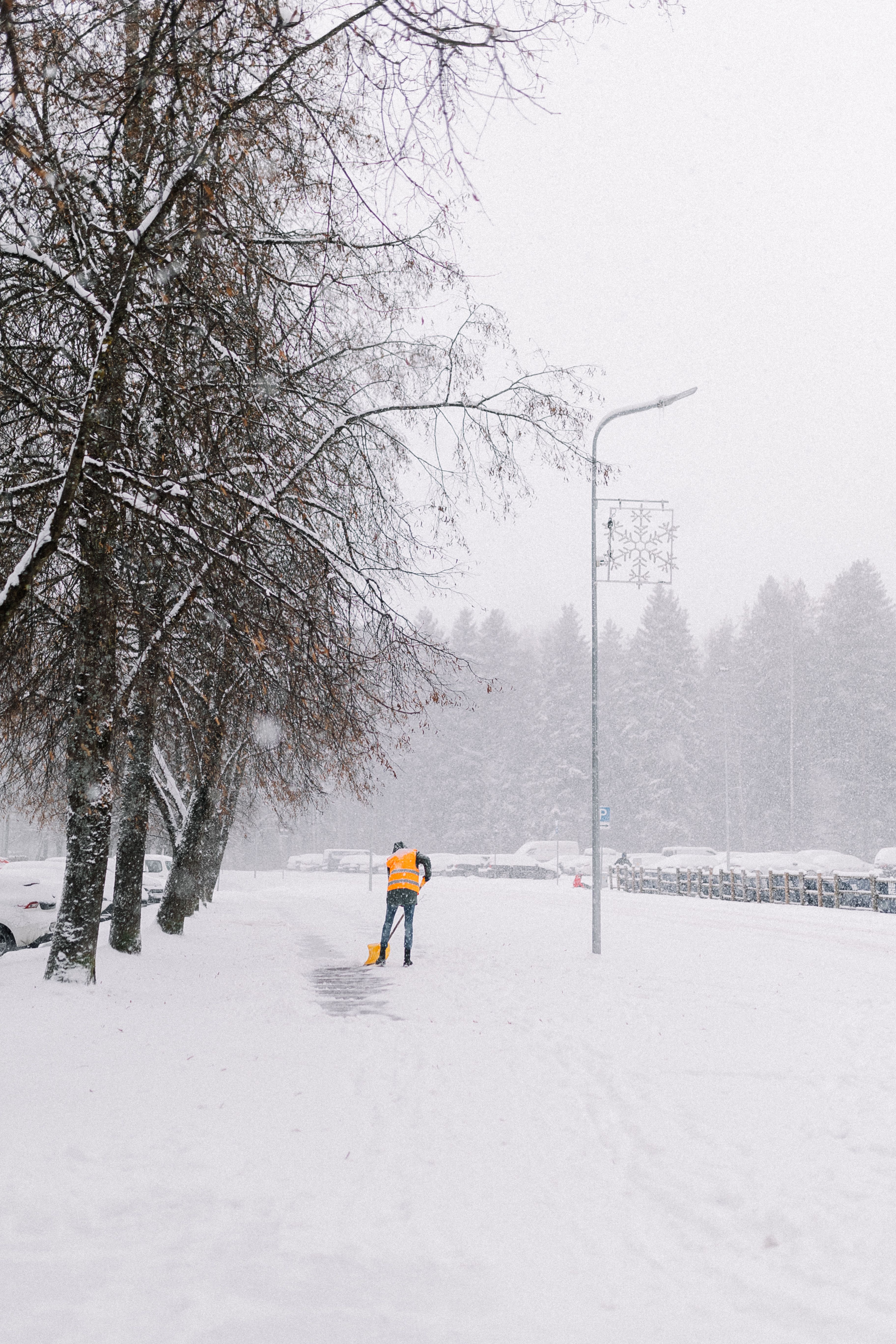Worker shoveling snow during a heavy winter snowfall · Free Stock Photo