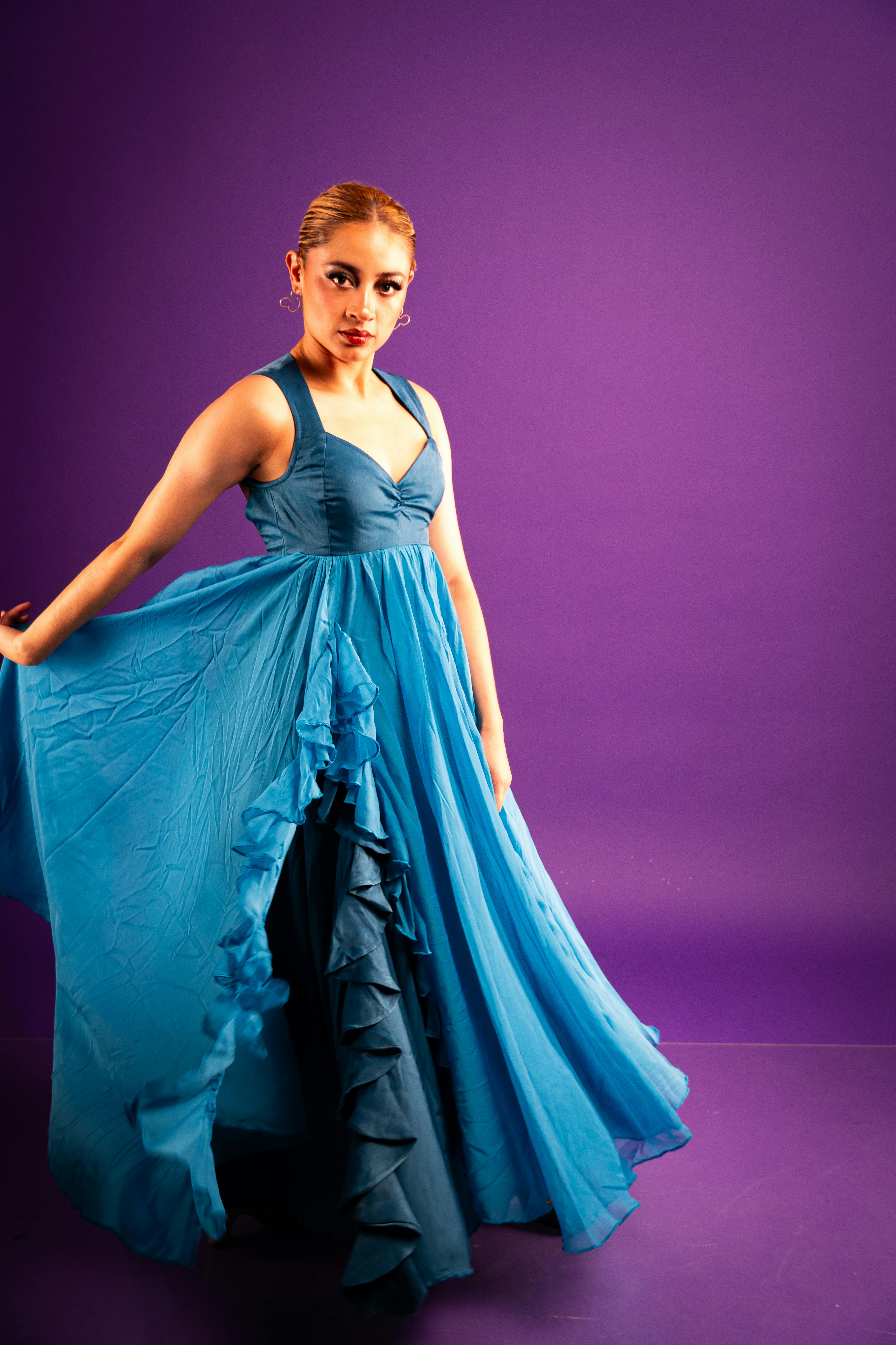 Elegant Model in Blue Dress against Purple Backdrop · Free Stock Photo