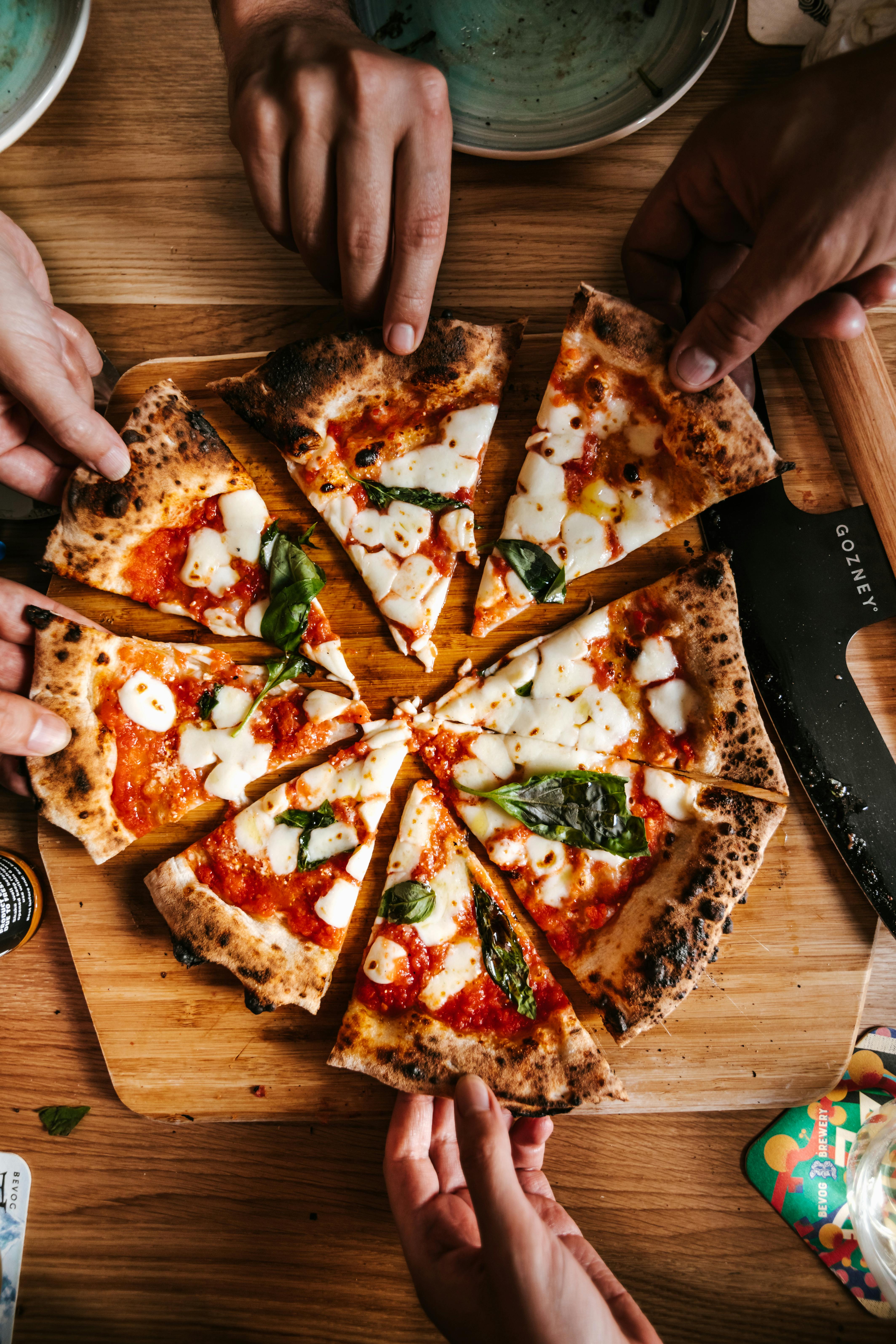 Sharing Sourdough Pizza with Friends in London · Free Stock Photo