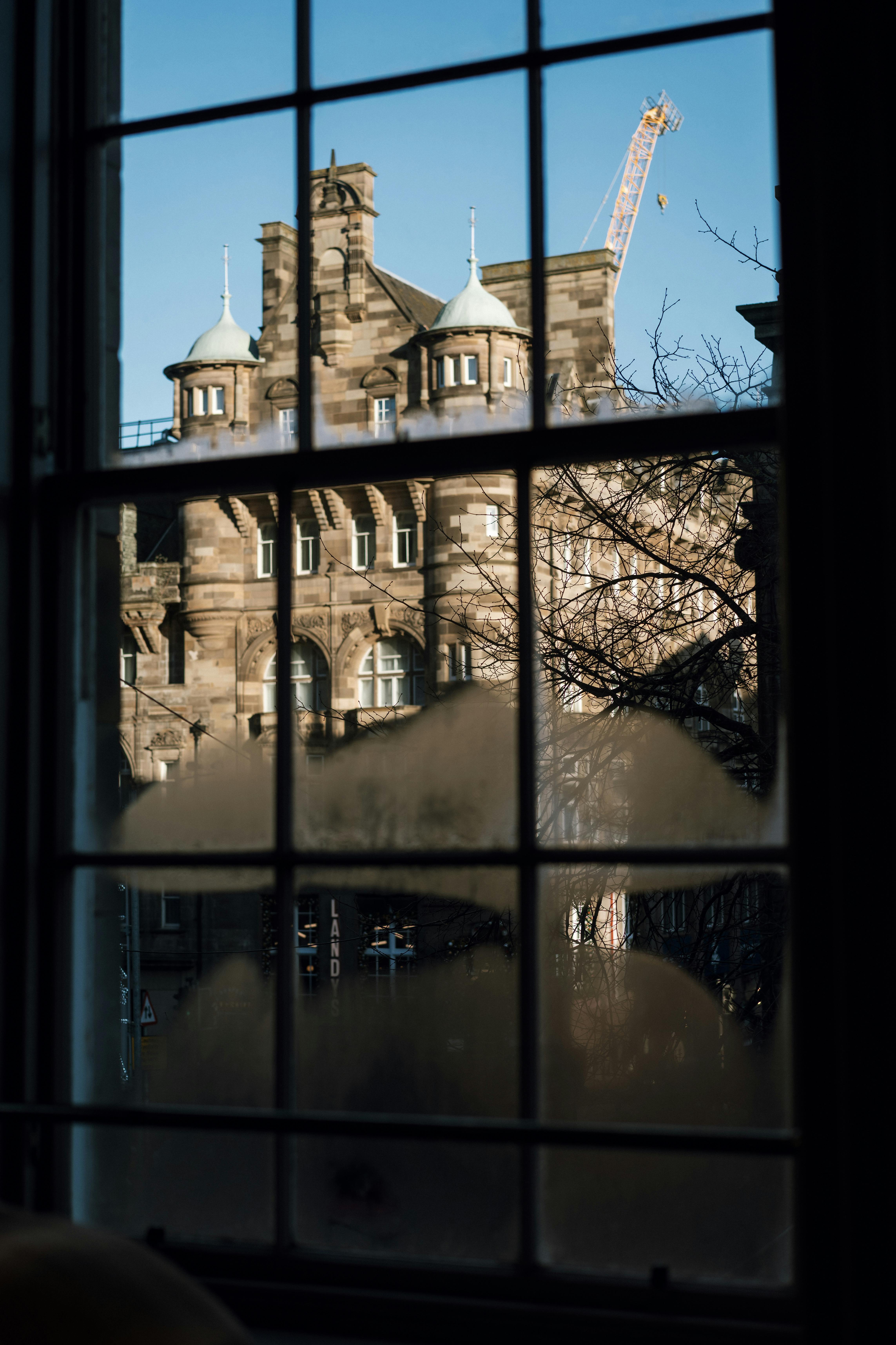 Urban Reflection through Historic Building Window · Free Stock Photo