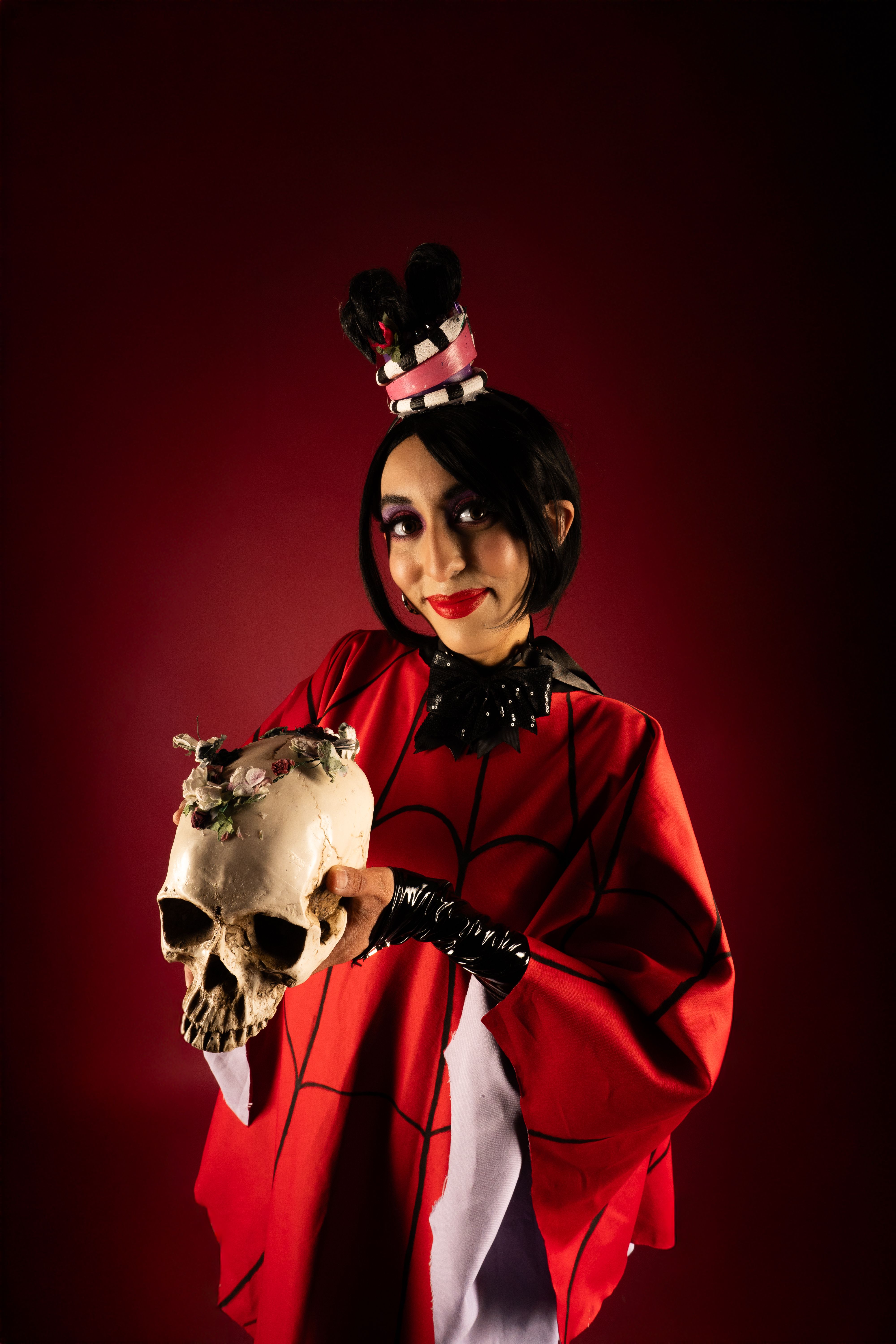 Cosplayer in Red Cape Holding Skull with Spider Detail · Free Stock Photo