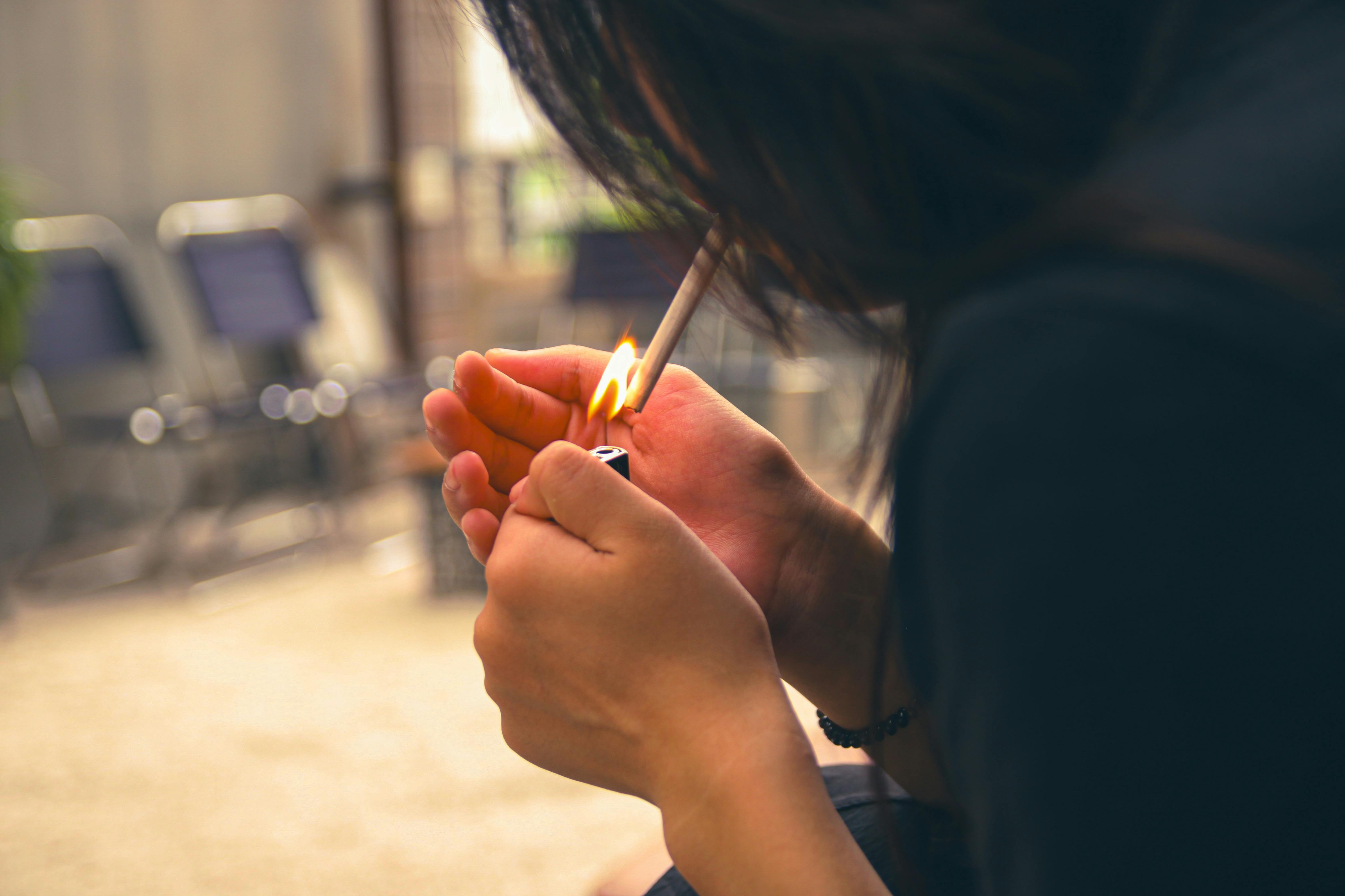Close-Up of Person Lighting Cigarette Outdoors · Free Stock Photo
