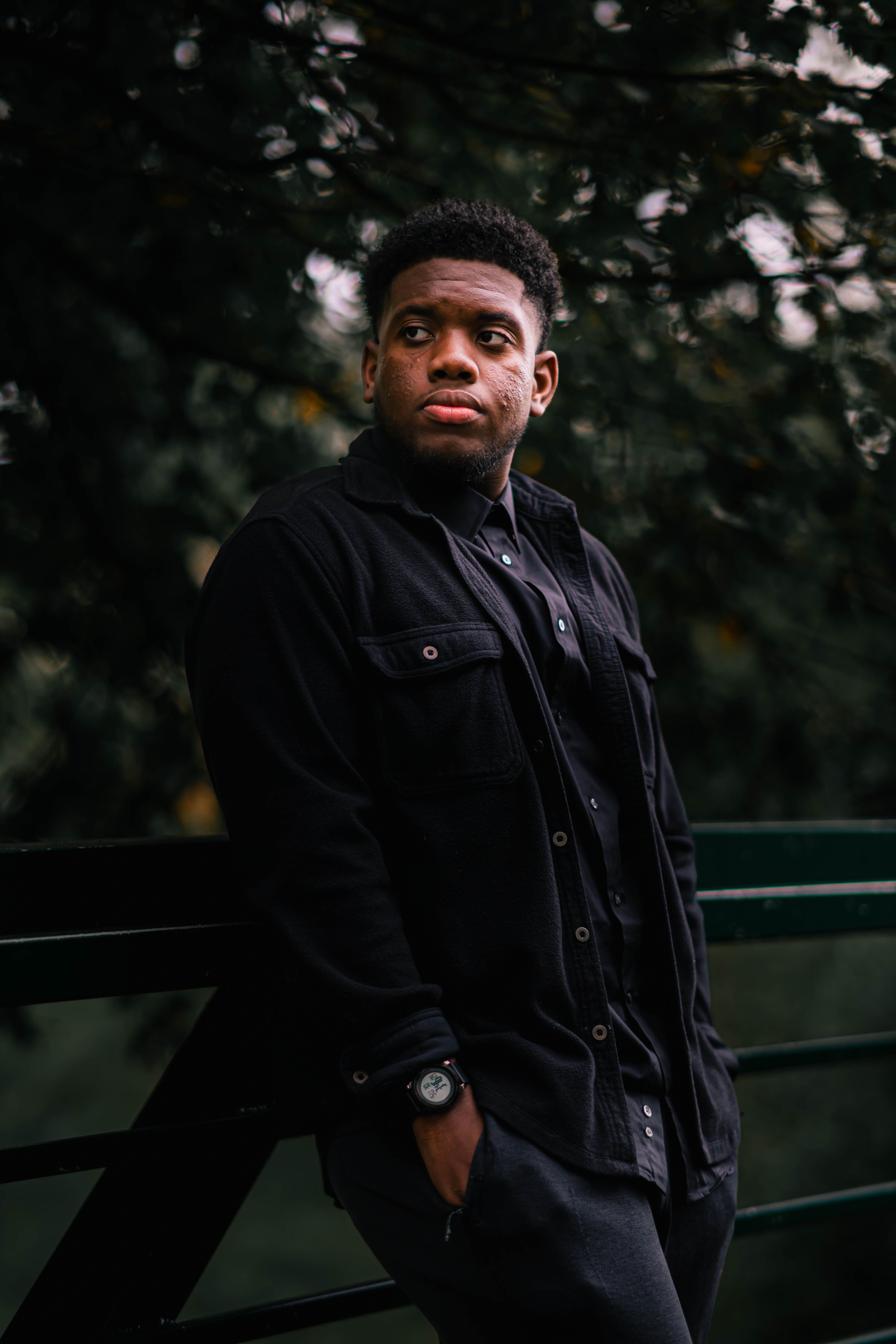 Pensive Man Leaning on Railing Outdoors · Free Stock Photo