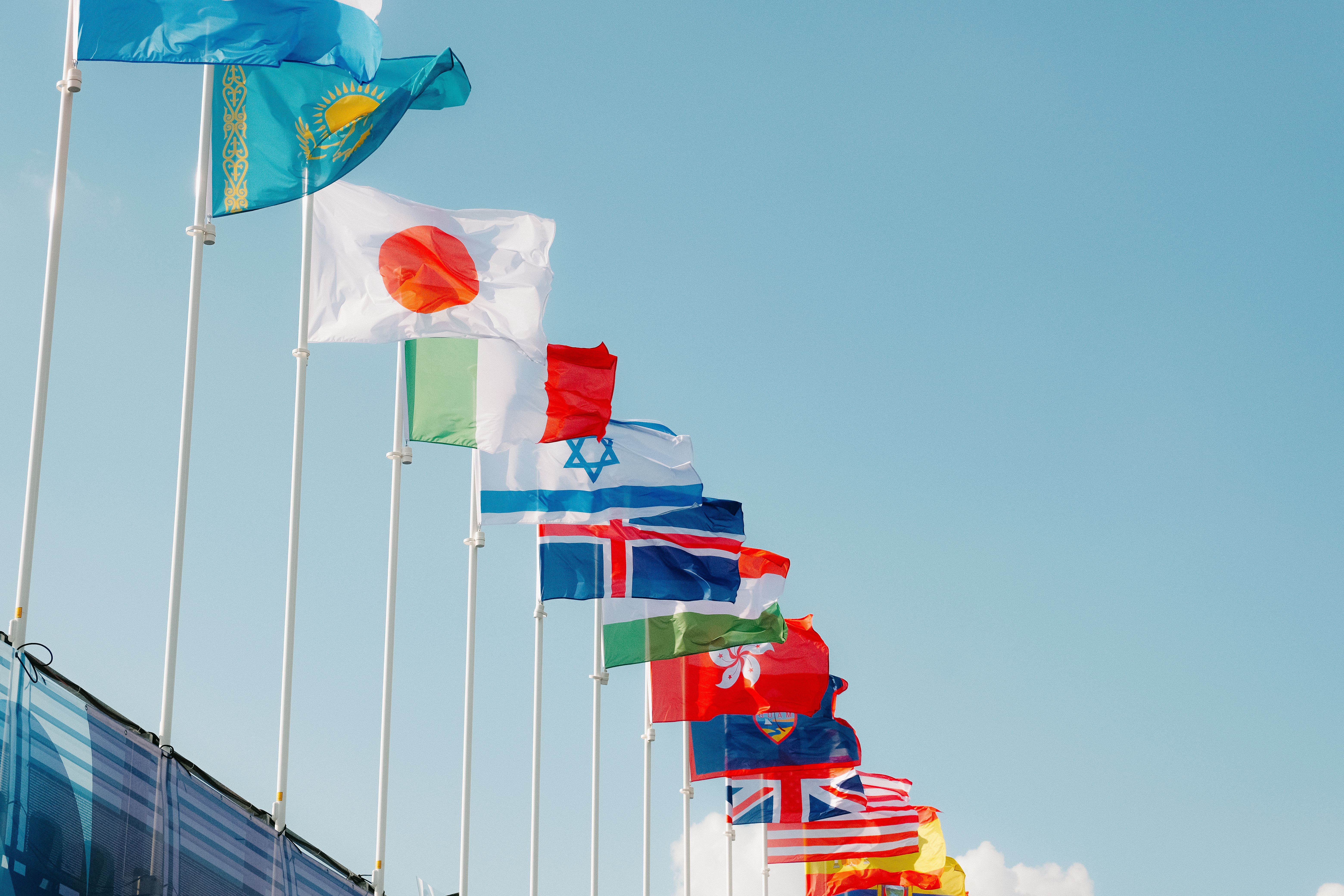 International Flags Waving Against Blue Sky · Free Stock Photo