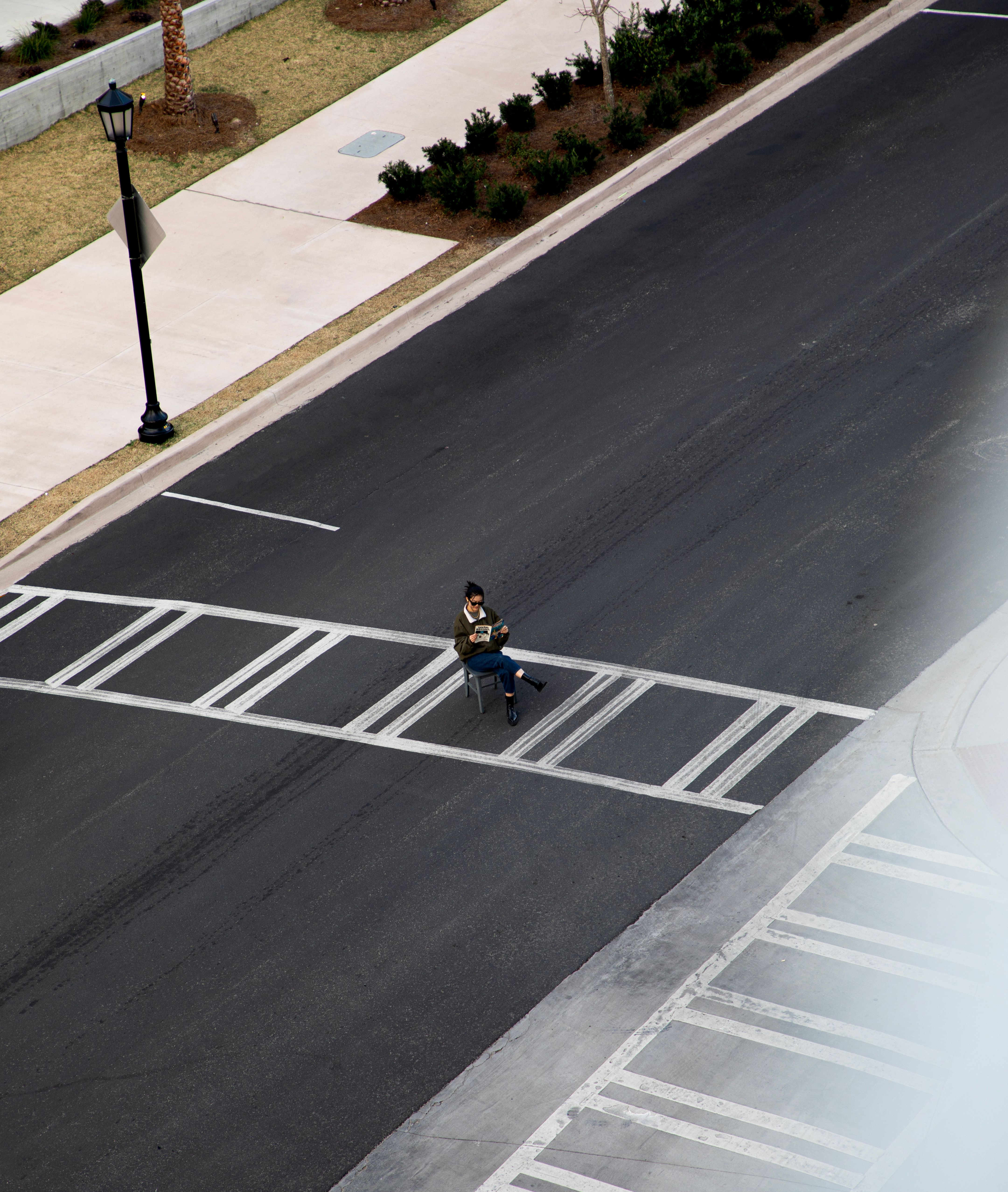 Solitary Reader on Urban Crosswalk from Above · Free Stock Photo