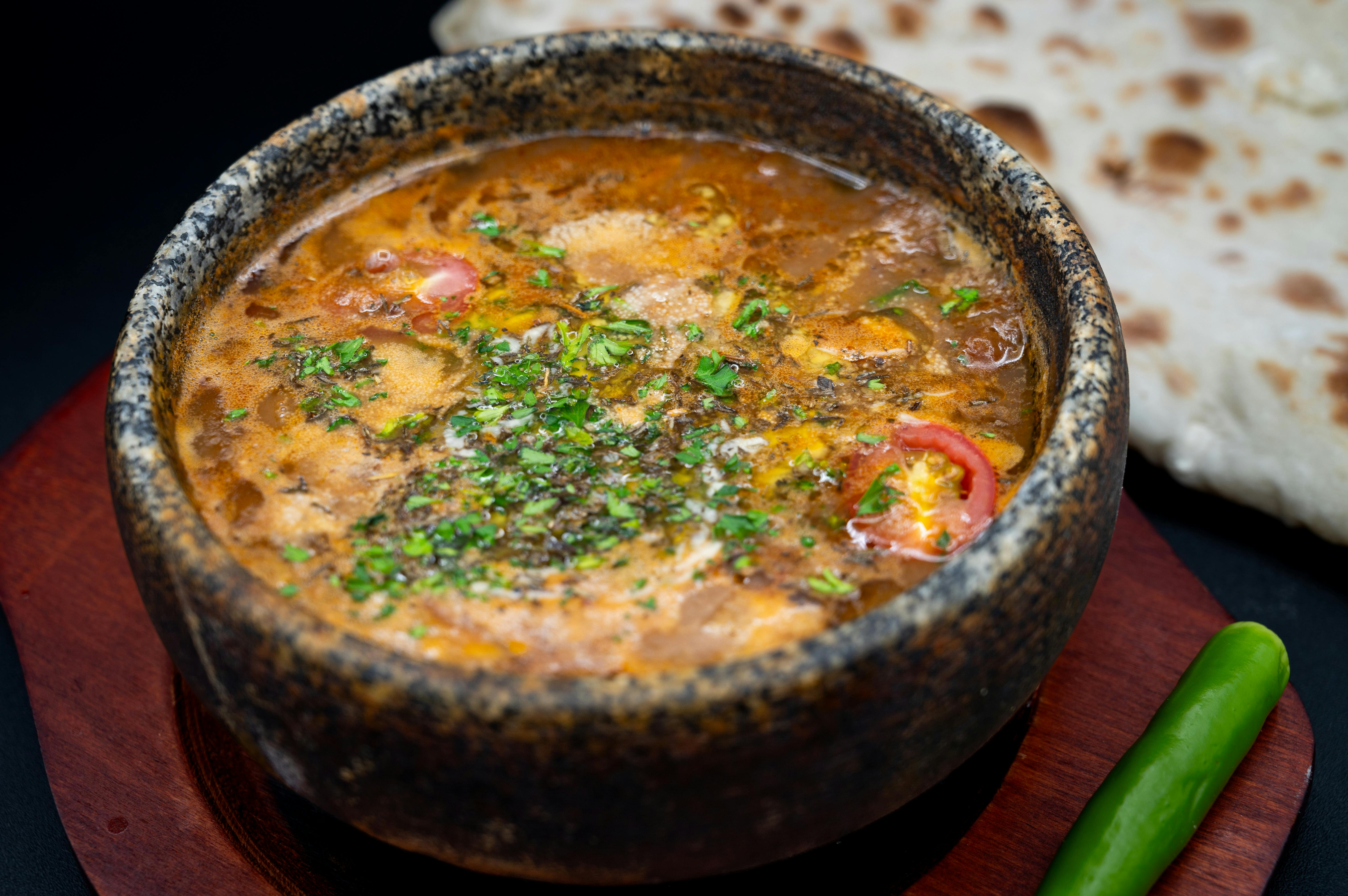 Middle Eastern Stew in Stone Bowl with Naan Bread · Free Stock Photo